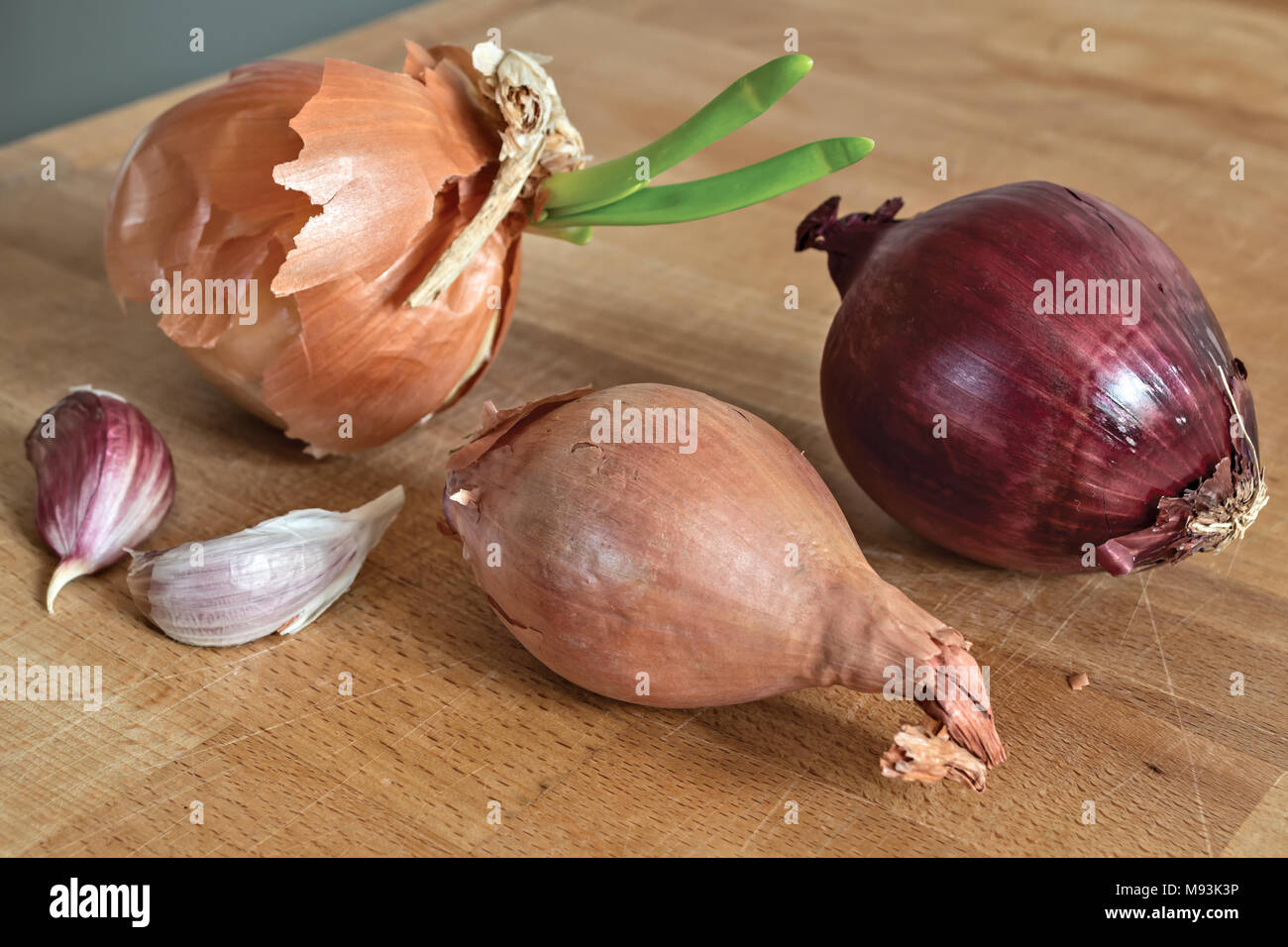 shallots onions and garlic on wooden chopping board 2 Stock Photo - Alamy