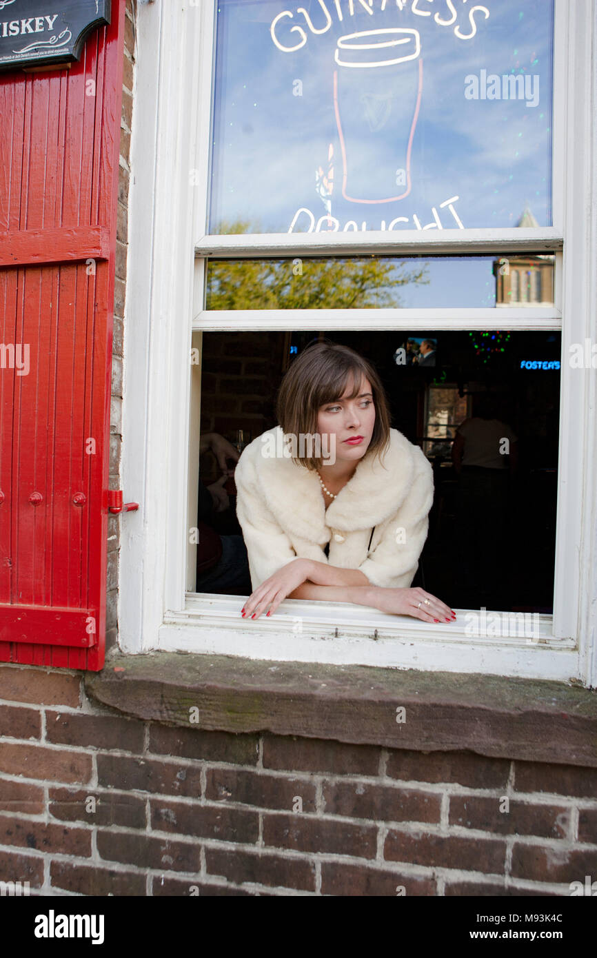 A woman with red lipstick, wearing a white fur jacket and a pearl ...