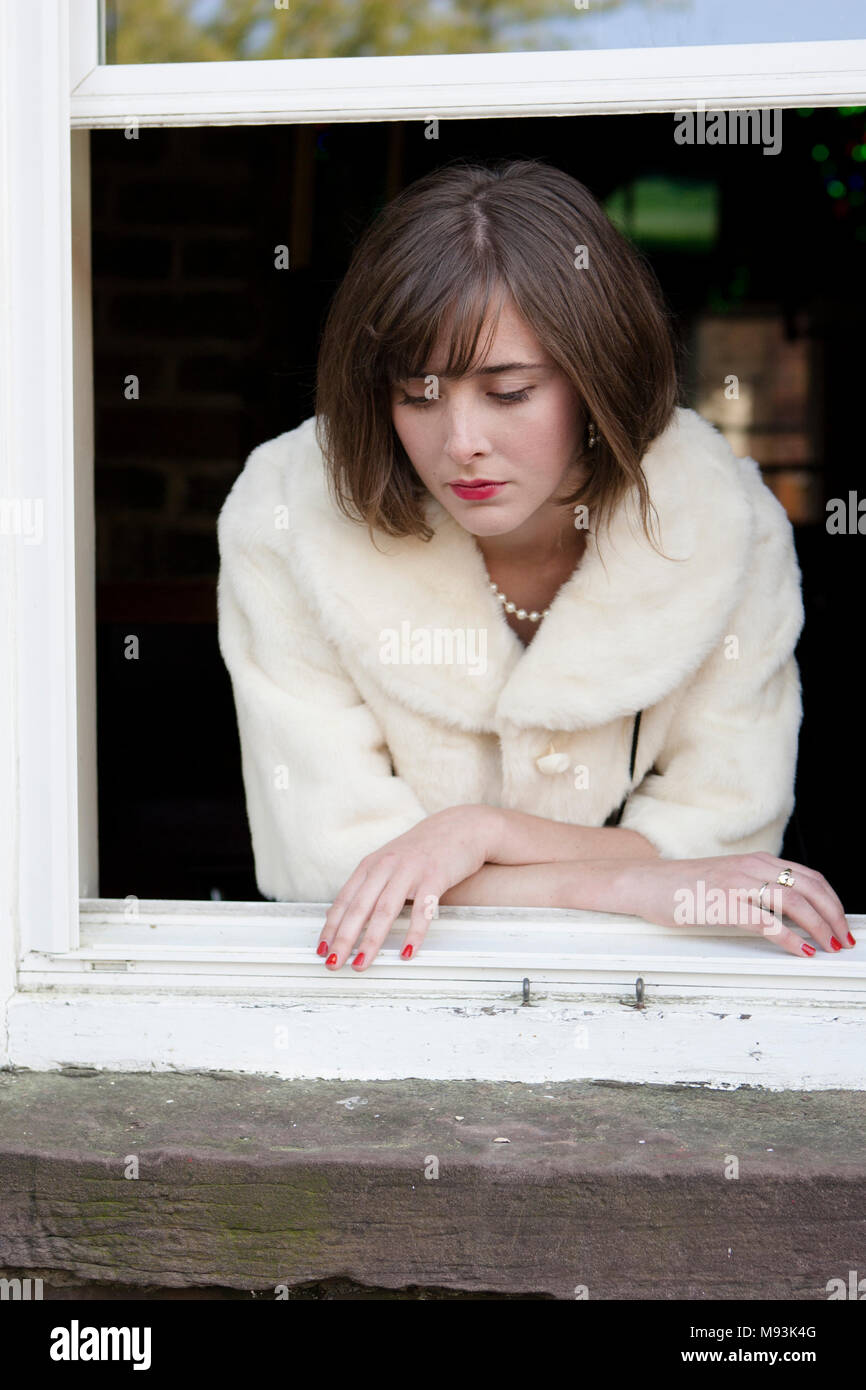A woman with red lipstick, wearing a white fur jacket and a pearl ...