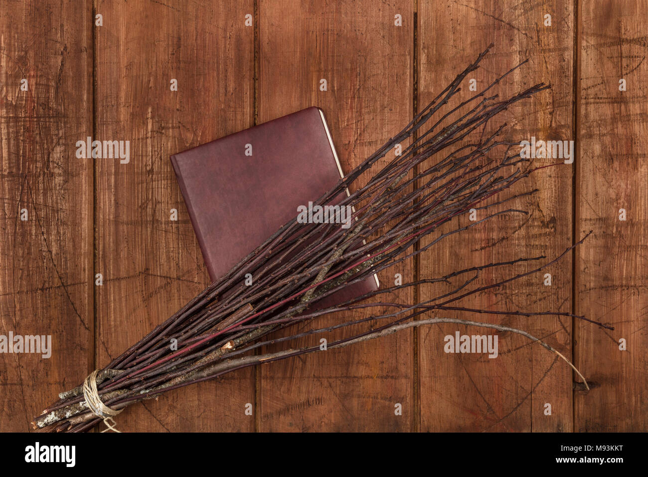 An overhead photo of a handmade witch's broom with a book of shadows ...
