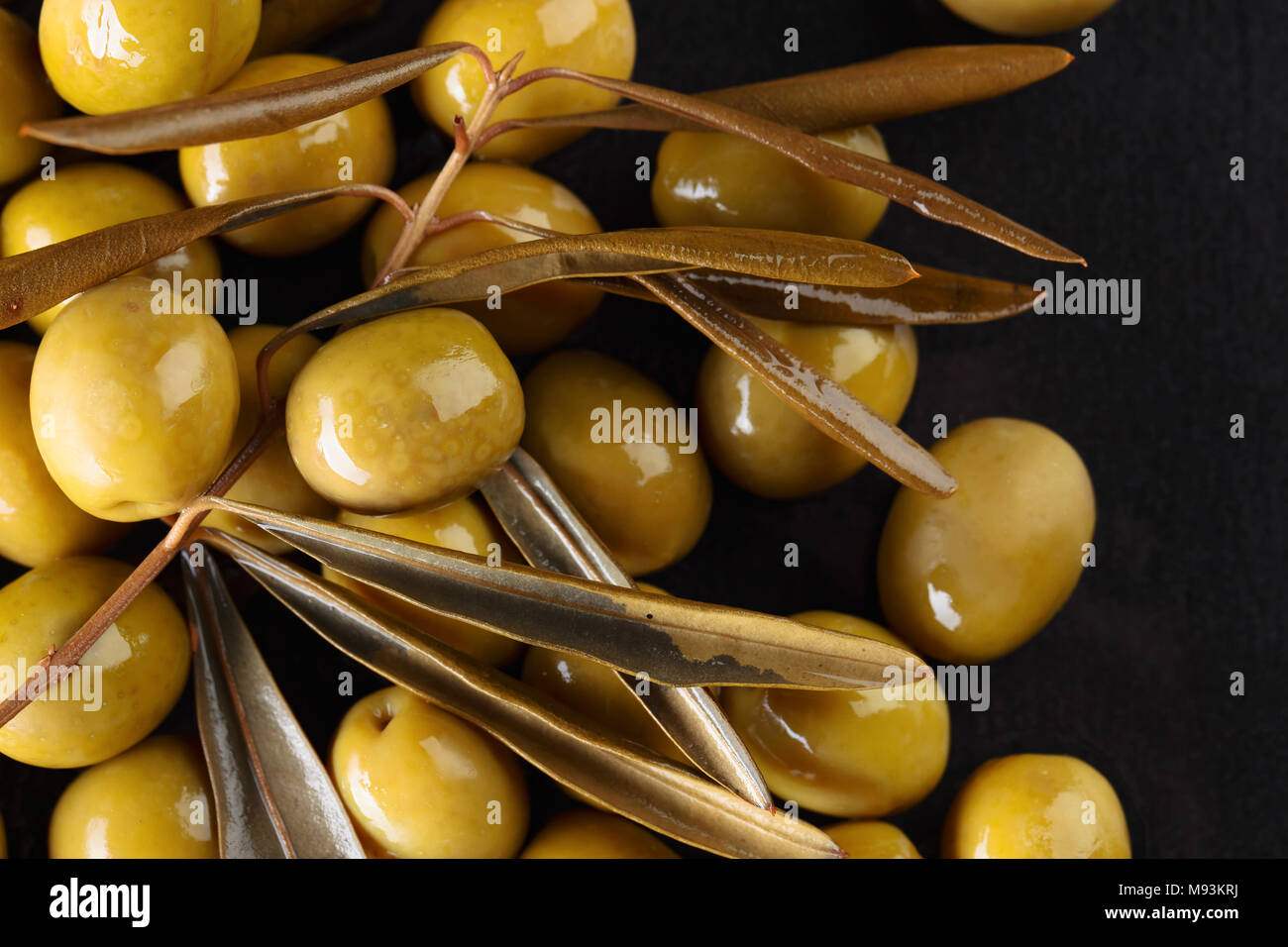Canned green olives with bone on a black stone table . Top view Stock ...