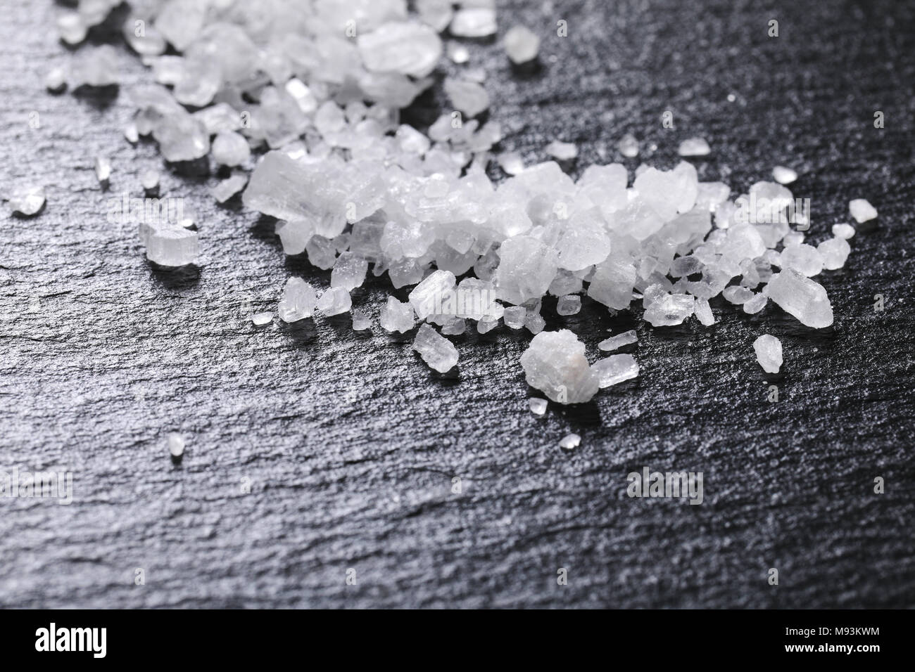 crystals of coarse grained sea salt on black background - detail Stock ...