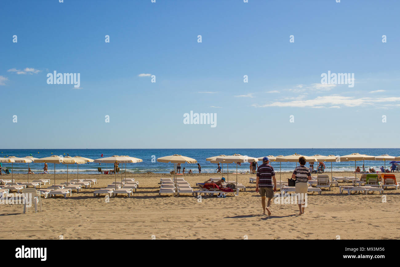 Couple walking on Spanish beach Stock Photo - Alamy