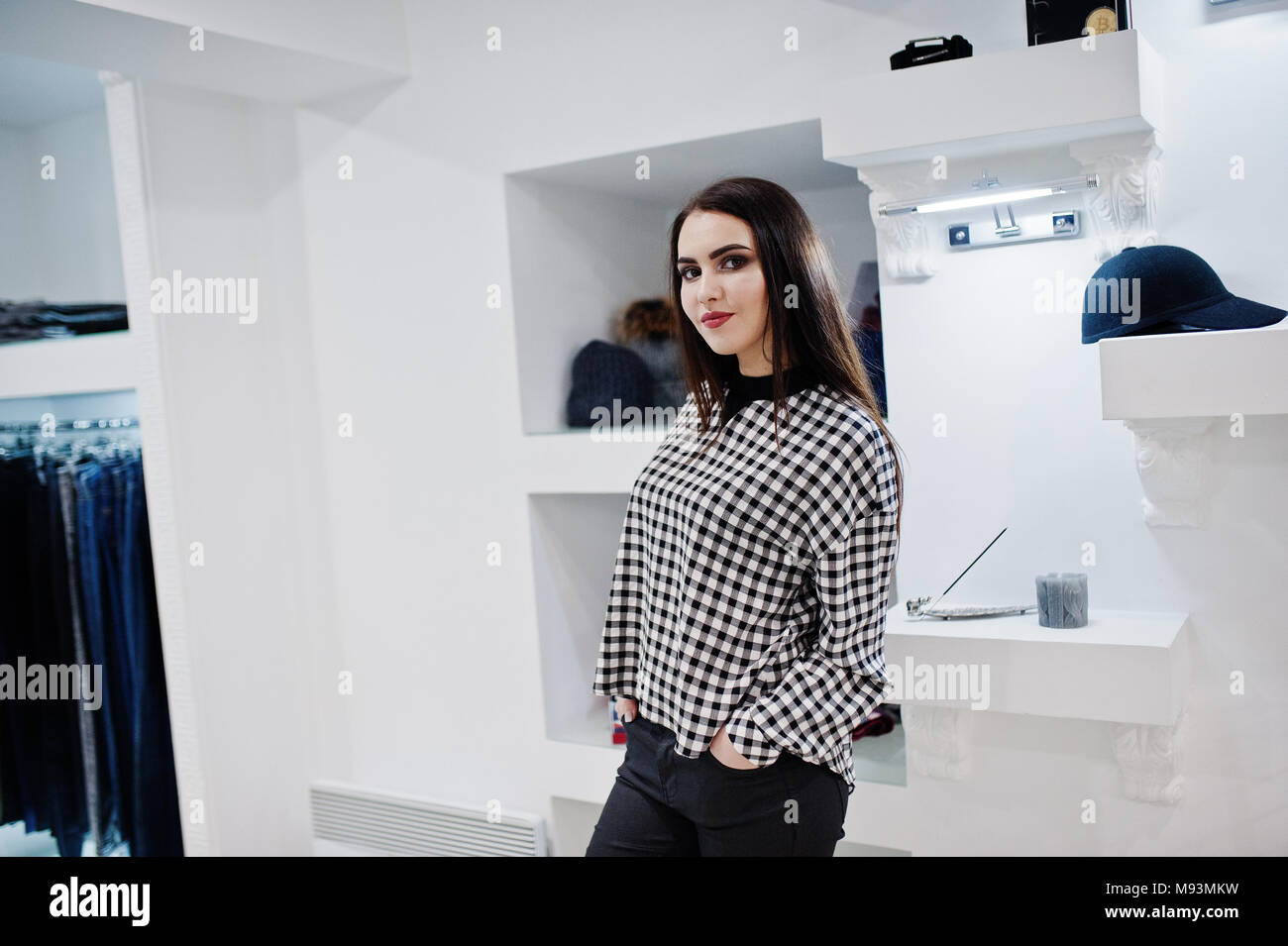 Brunette gorgeous girl in the clothing store boutique at casual clothes ...