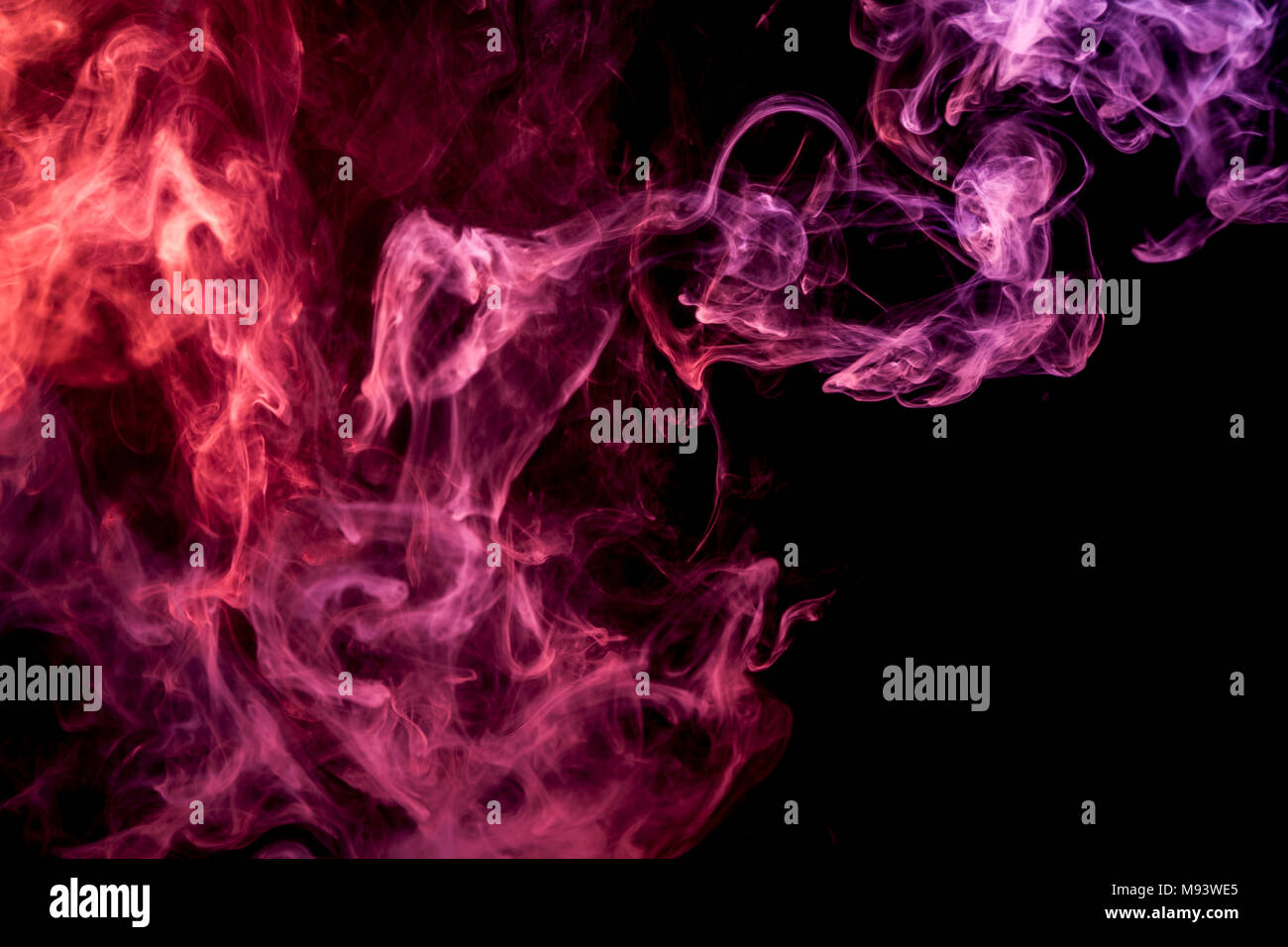 Pink, red and purple cloud of smoke of black isolated background ...