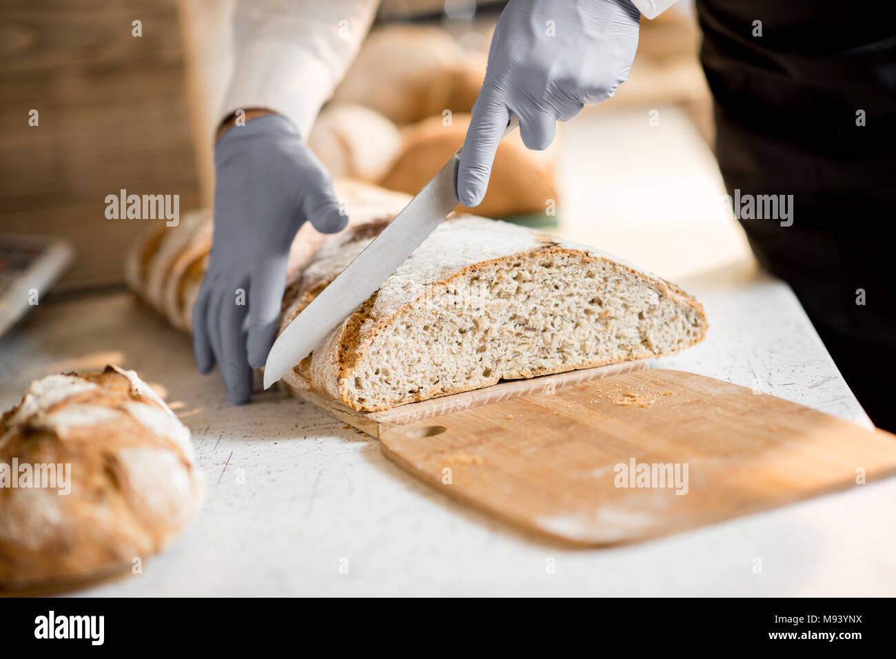 Cutting a bread in the store Stock Photo - Alamy