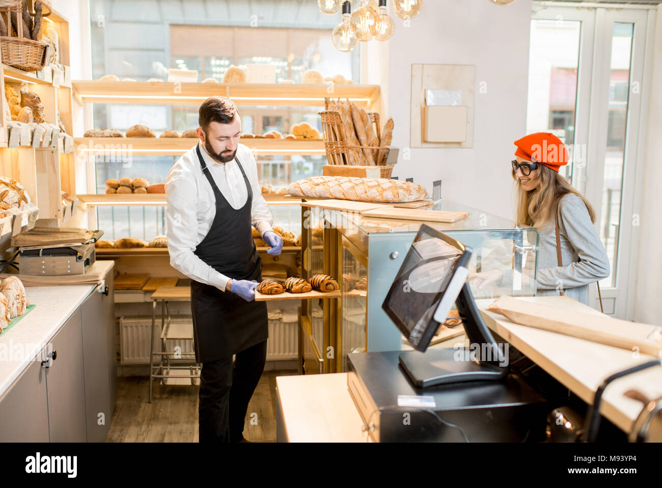 Seller with customer in the bakery store Stock Photo - Alamy
