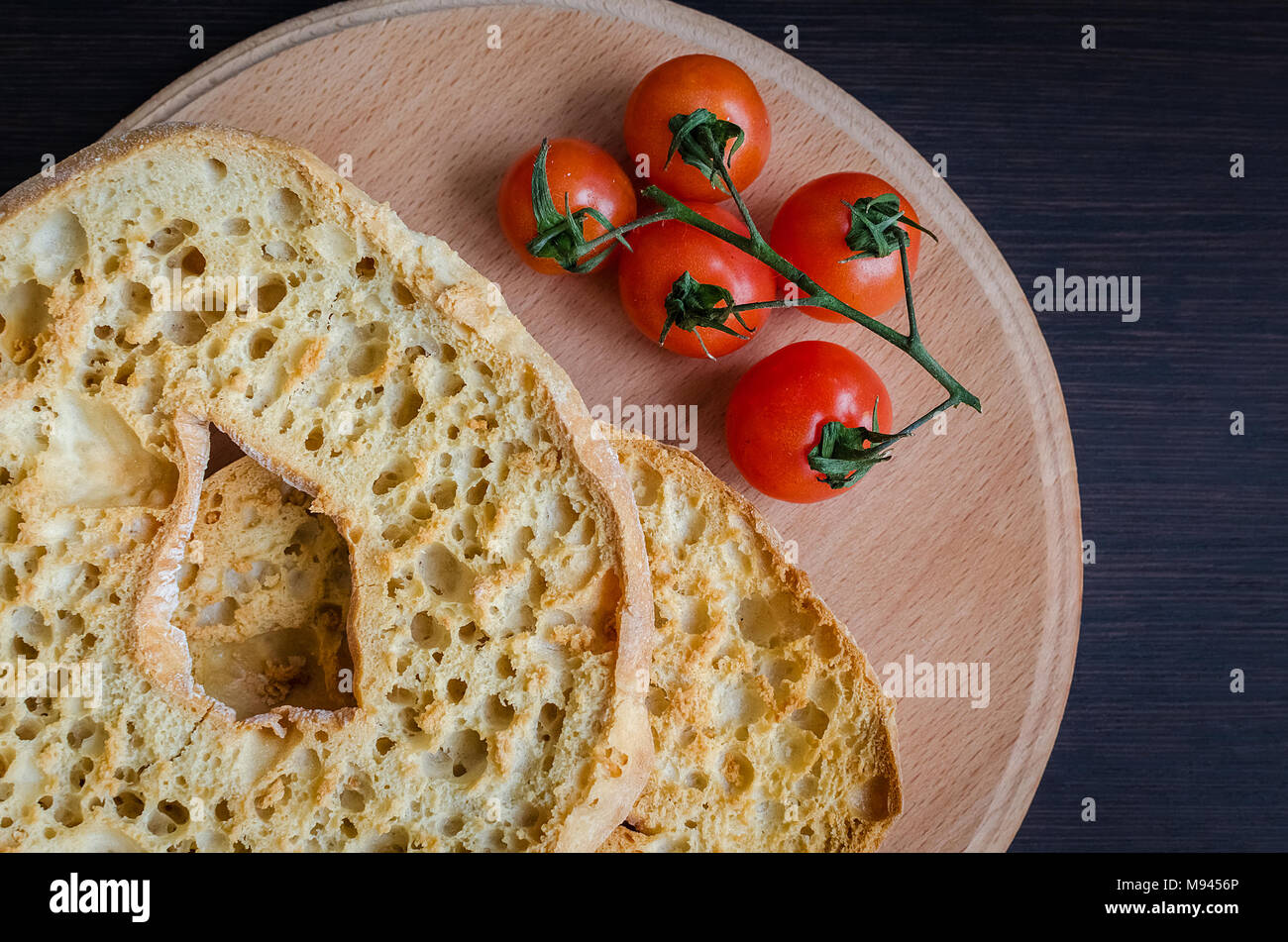 Italian dried bread Friselle on wooden board with tomatoes cherry ...