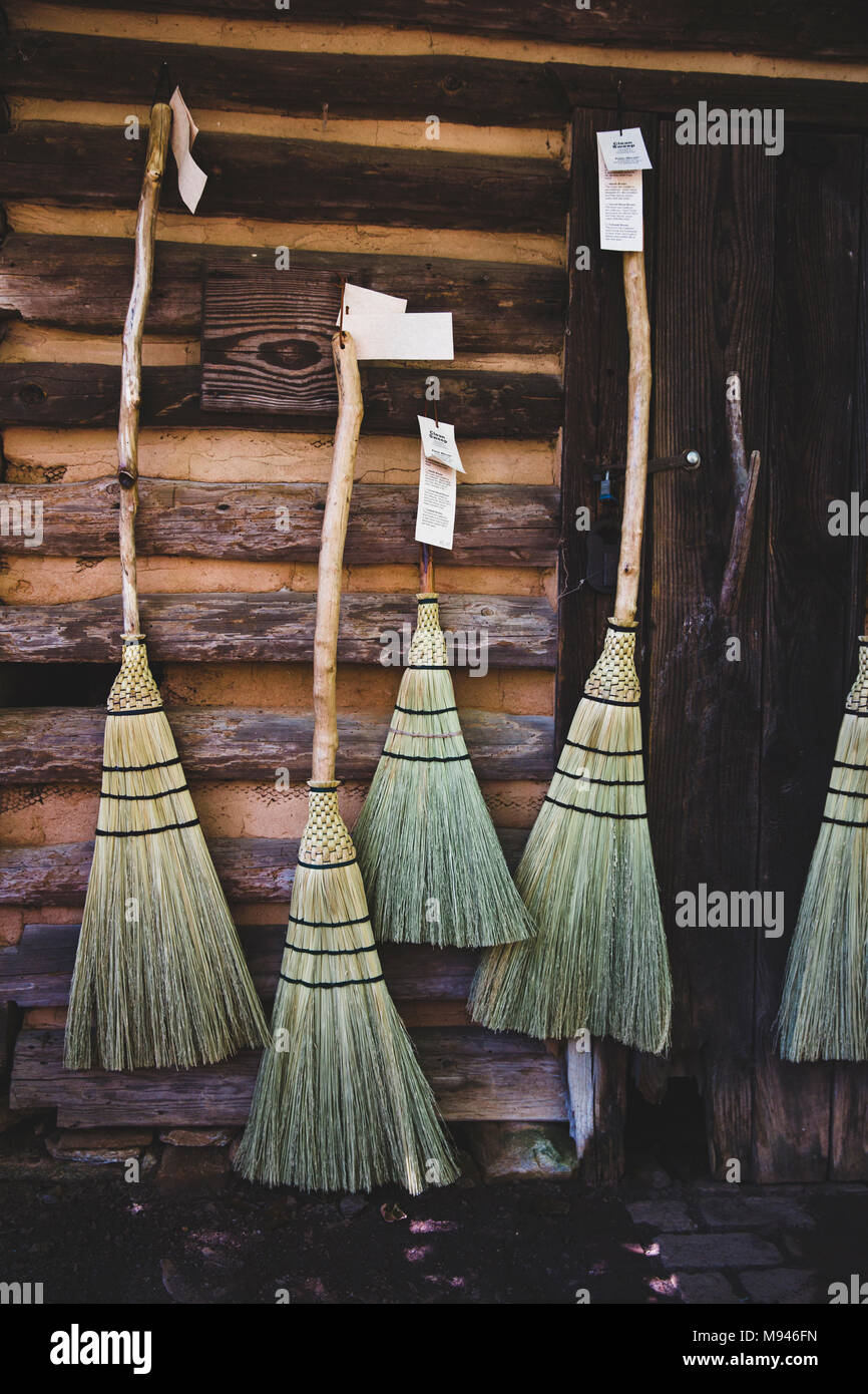 Brooms hanging up against wooden wall Stock Photo - Alamy