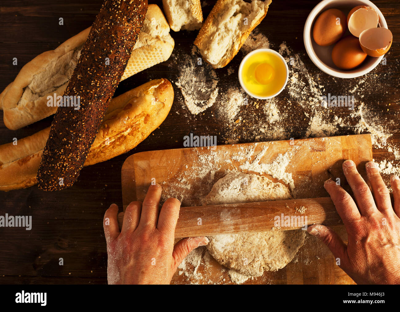Baker making fresh organic bread in kitchen. Top down shot of ...