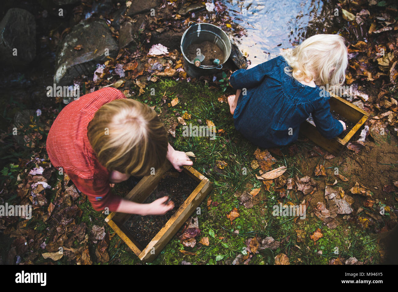Children using panning buckets next to river Stock Photo - Alamy