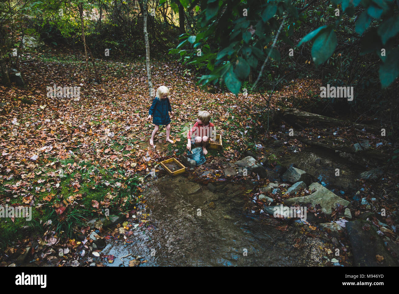 Children using panning buckets next to river Stock Photo - Alamy