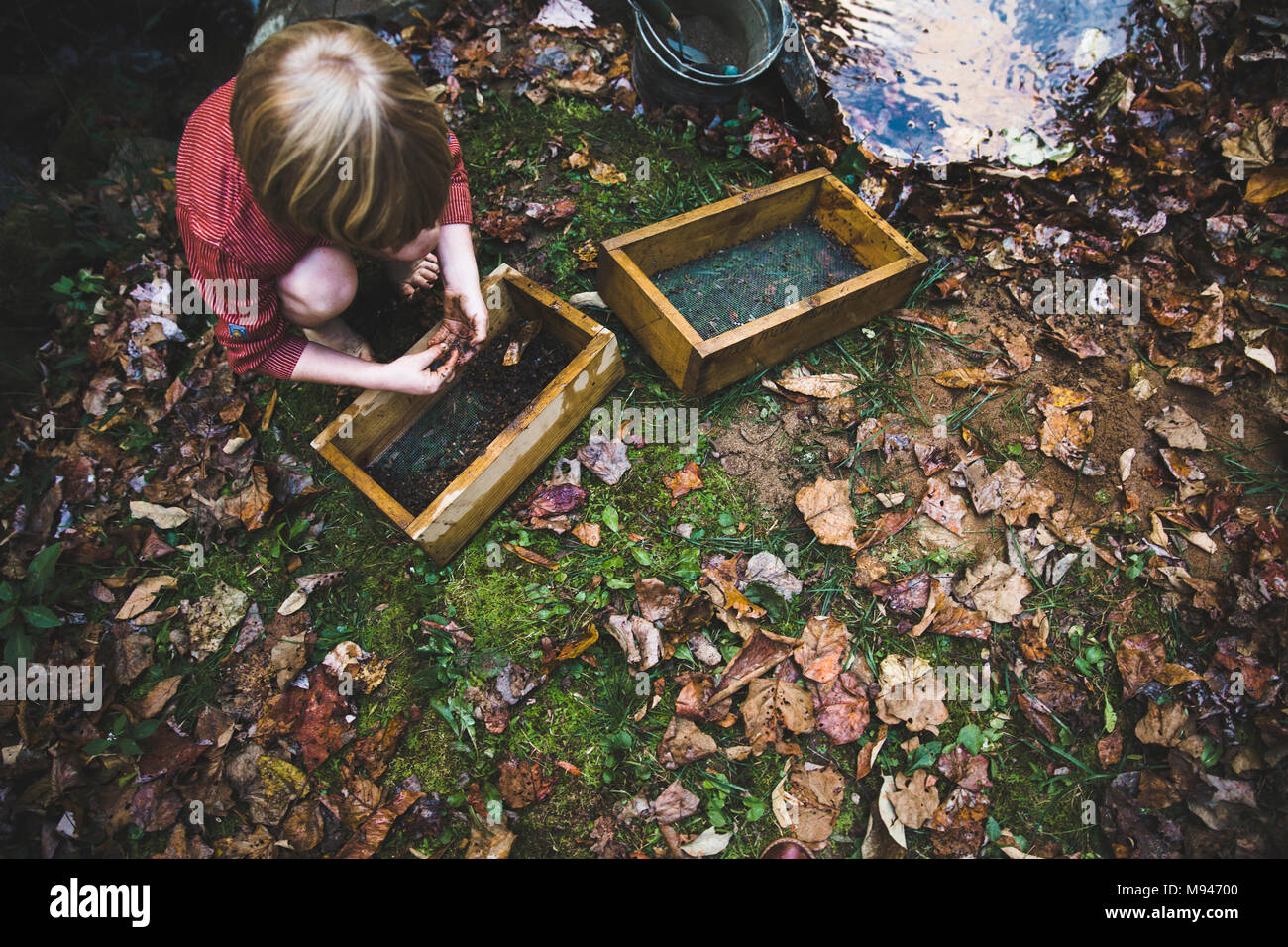 Children using panning buckets next to river Stock Photo - Alamy
