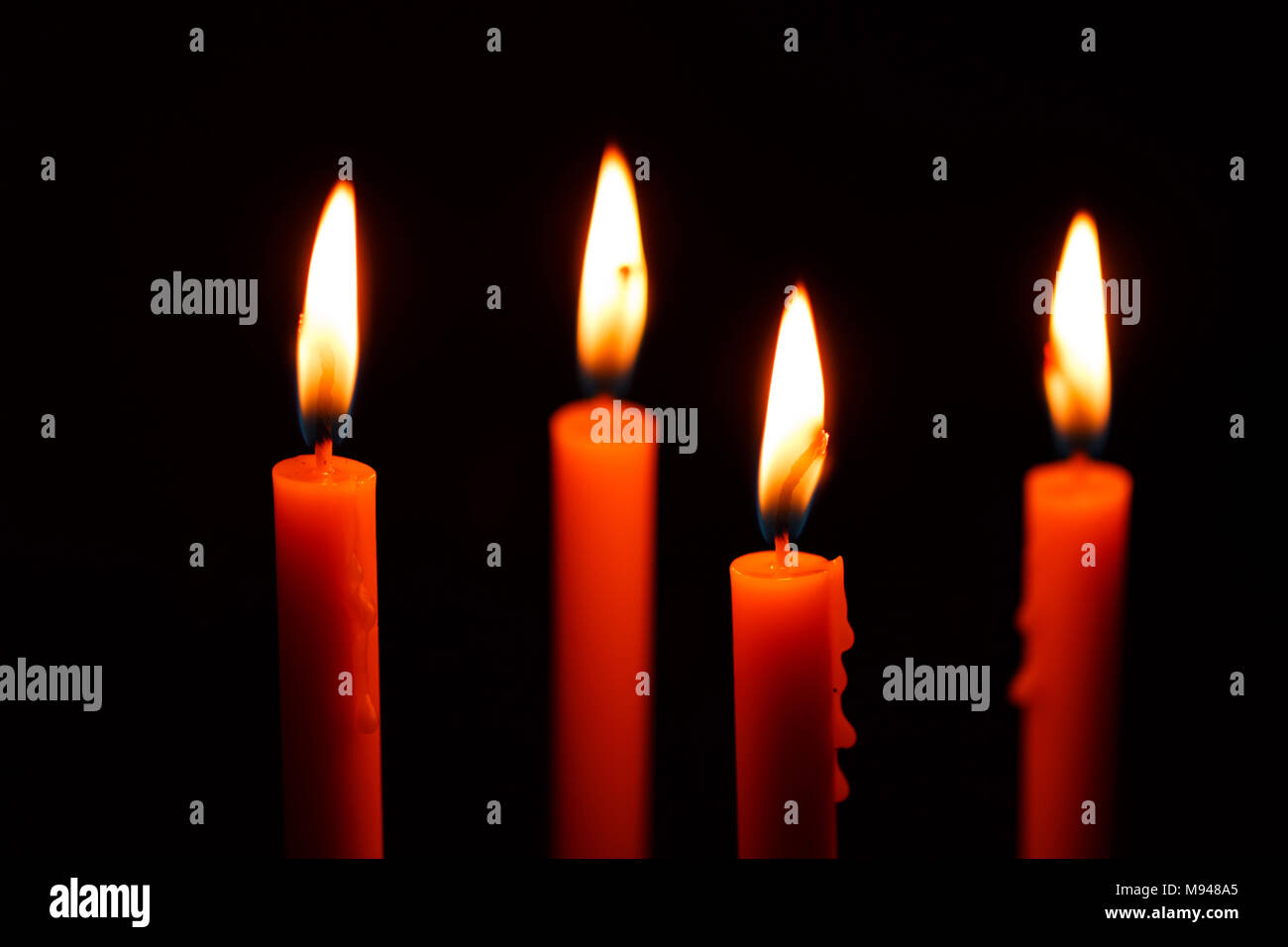 four candles on black background Stock Photo - Alamy