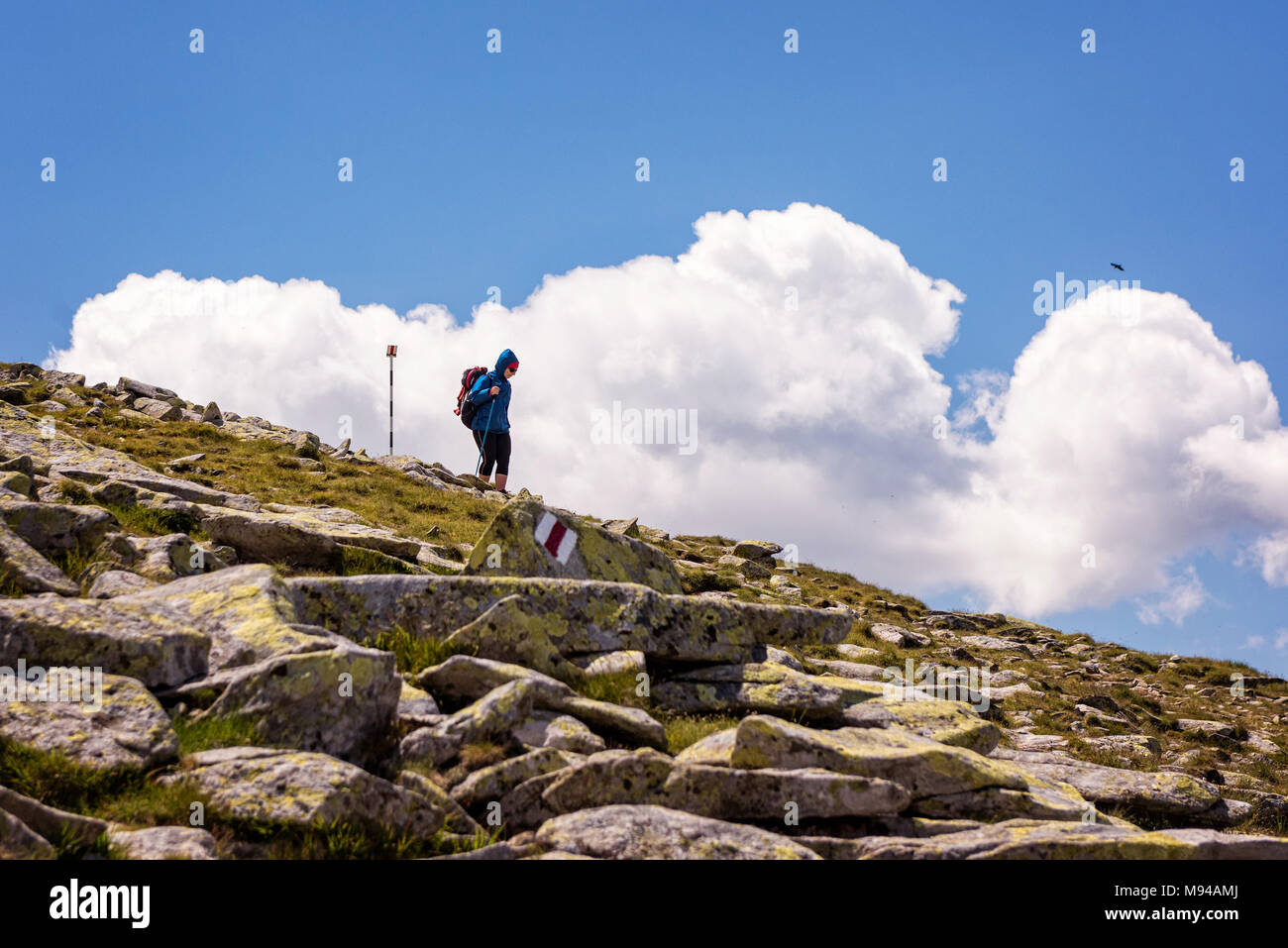 Young woman silhouette hiking down a steep mountain path with white ...