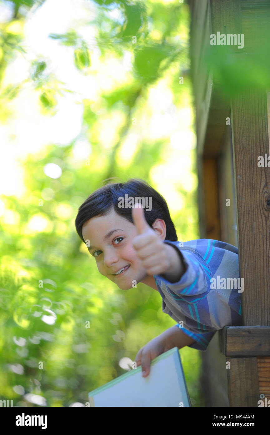 Child reading a book in the window of his hut Stock Photo - Alamy