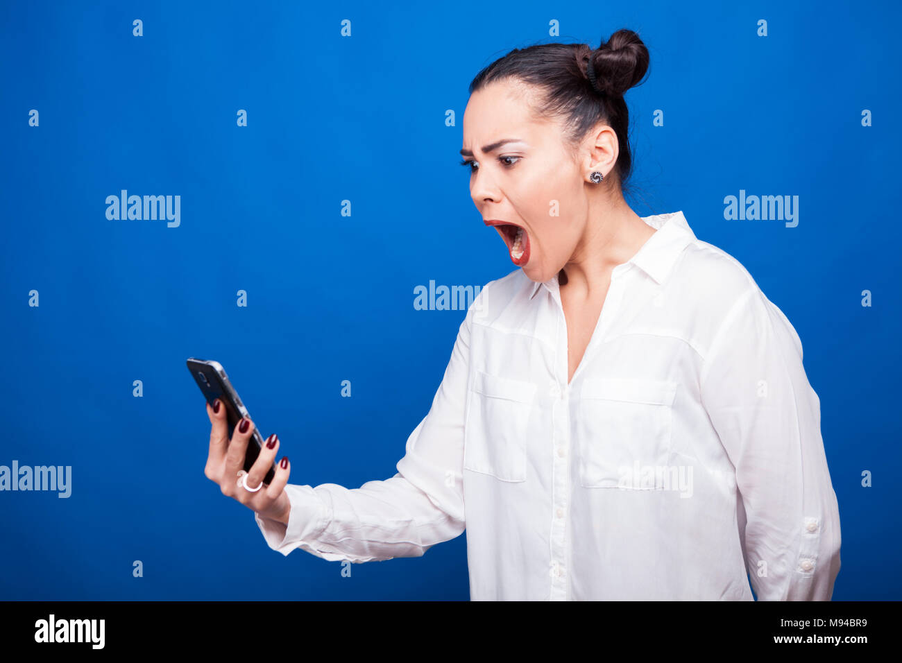 Angry woman yelling at the phone Stock Photo - Alamy