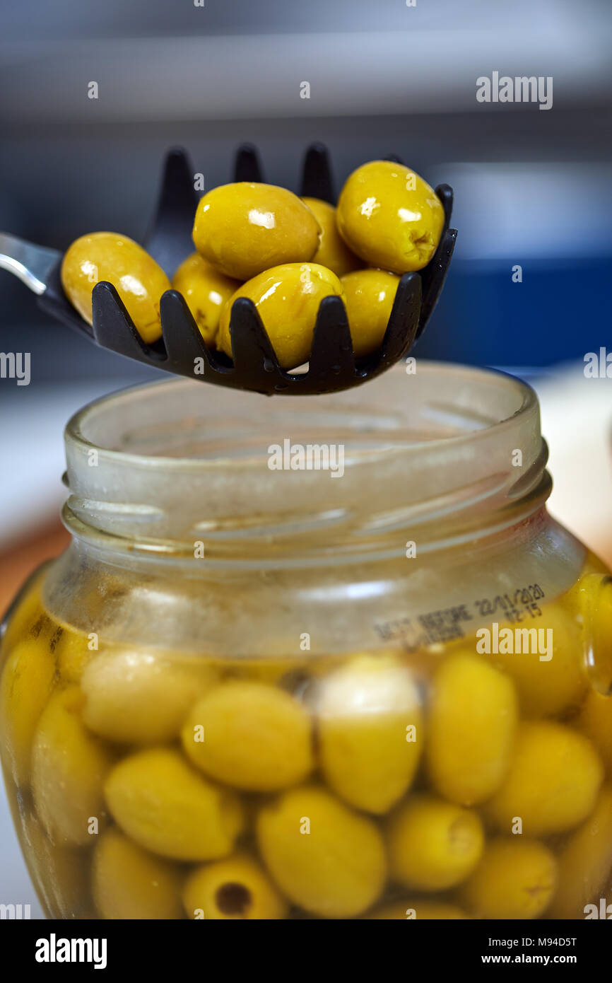 Closeup of canned green olives in a big jar Stock Photo - Alamy