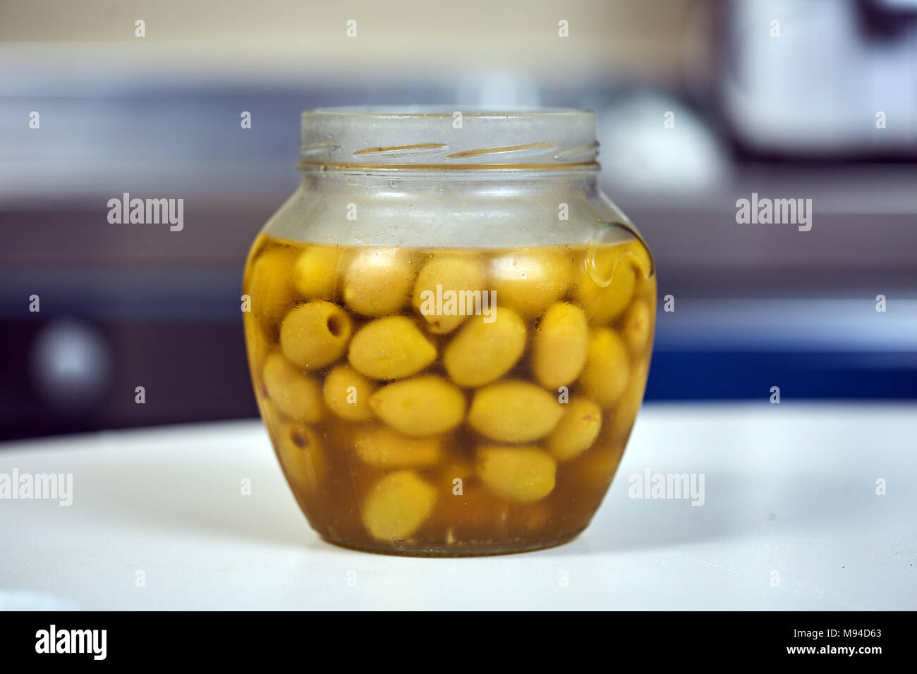 Closeup of canned green olives in a big jar Stock Photo - Alamy