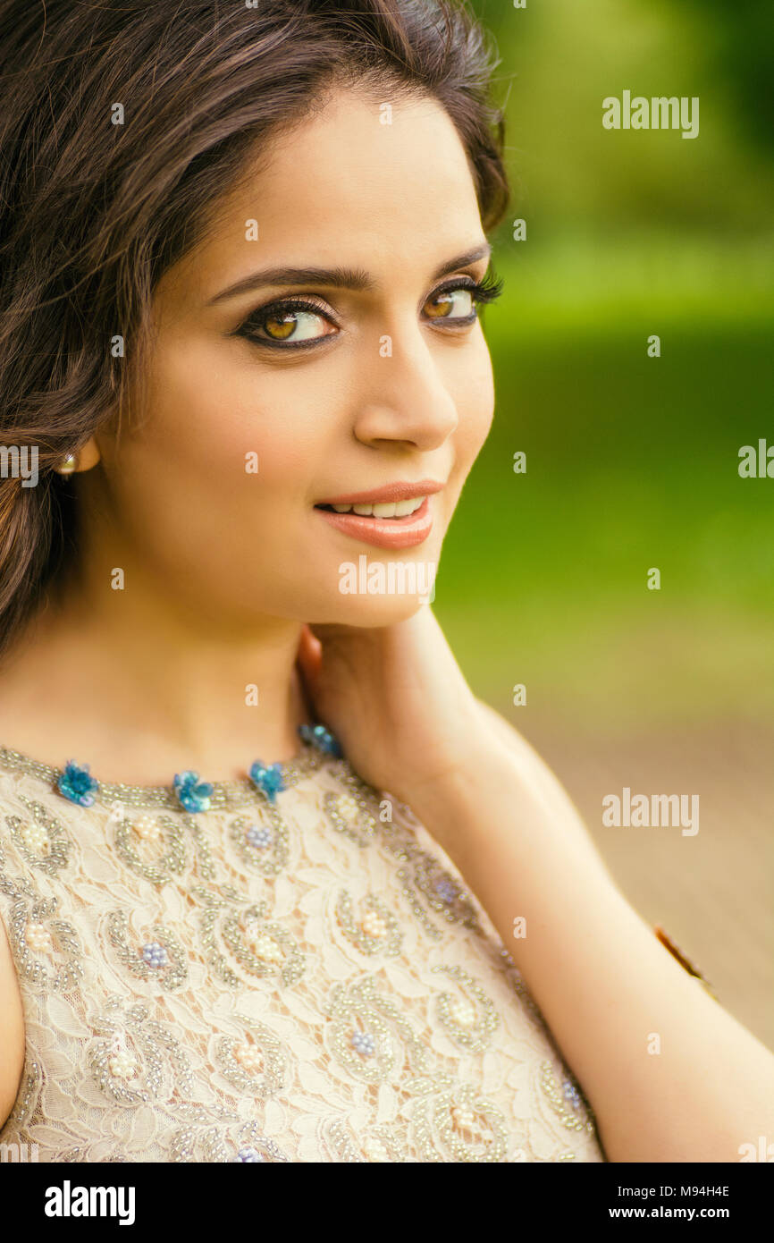 Beautiful young woman hand touching neck smiling outdoors Stock Photo ...