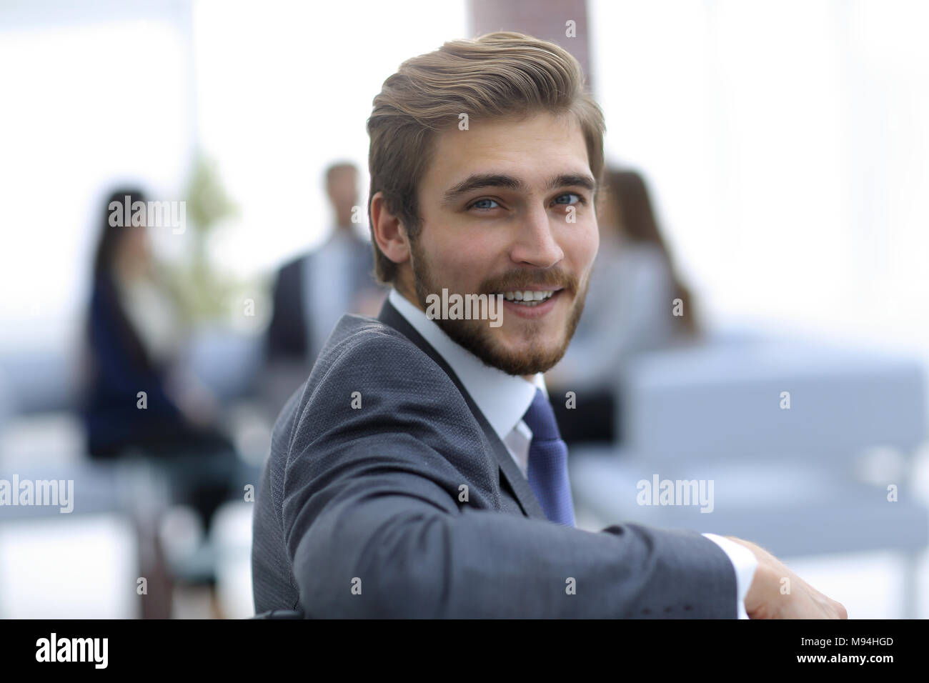 Successful business man standing with his staff in background at Stock ...