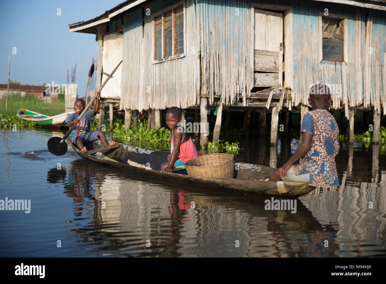 Children travel on a pirogue in Ganvie, southern Benin Stock Photo - Alamy
