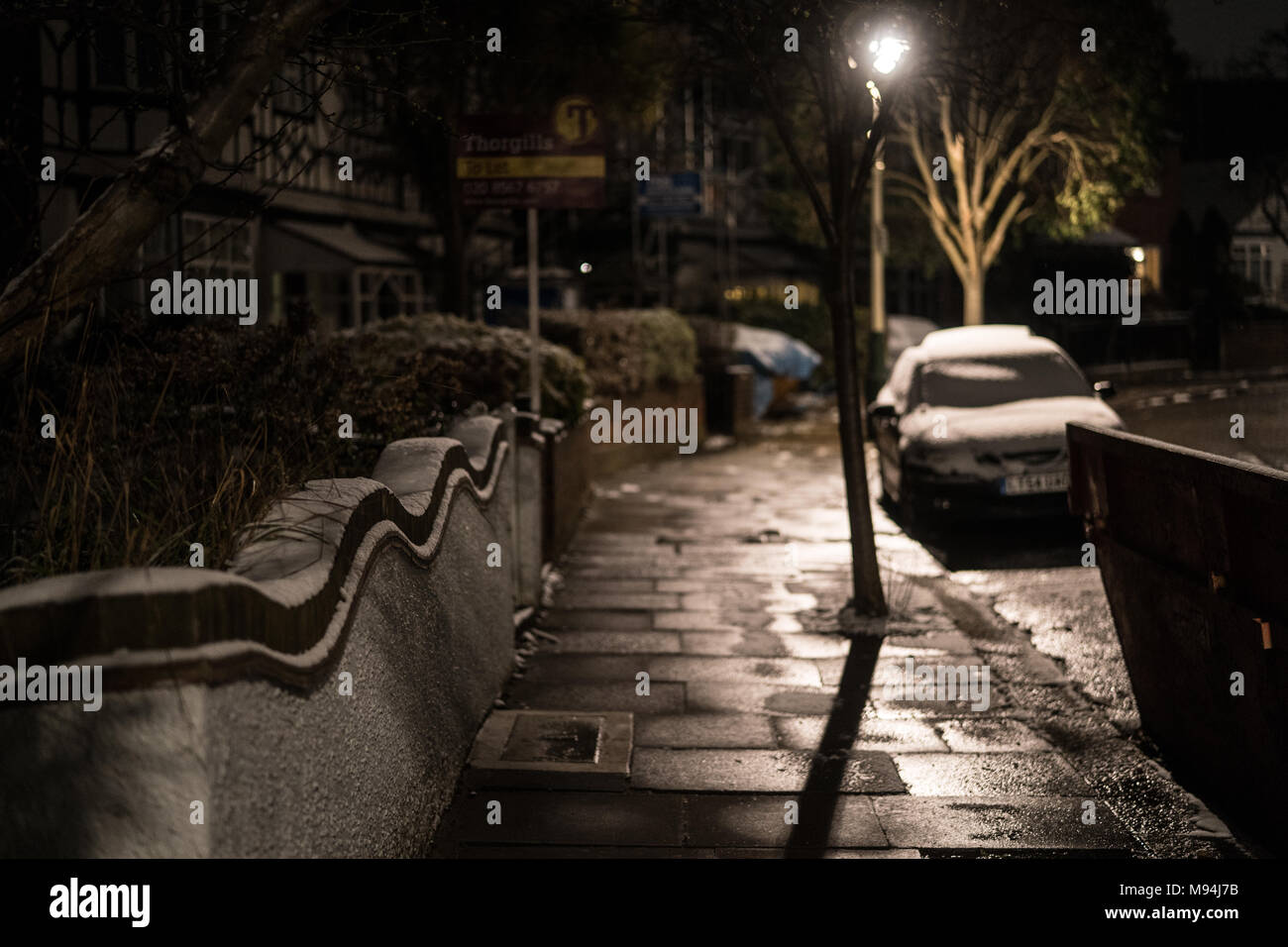 Cars on a suburban street in London after a light downfall of snow ...