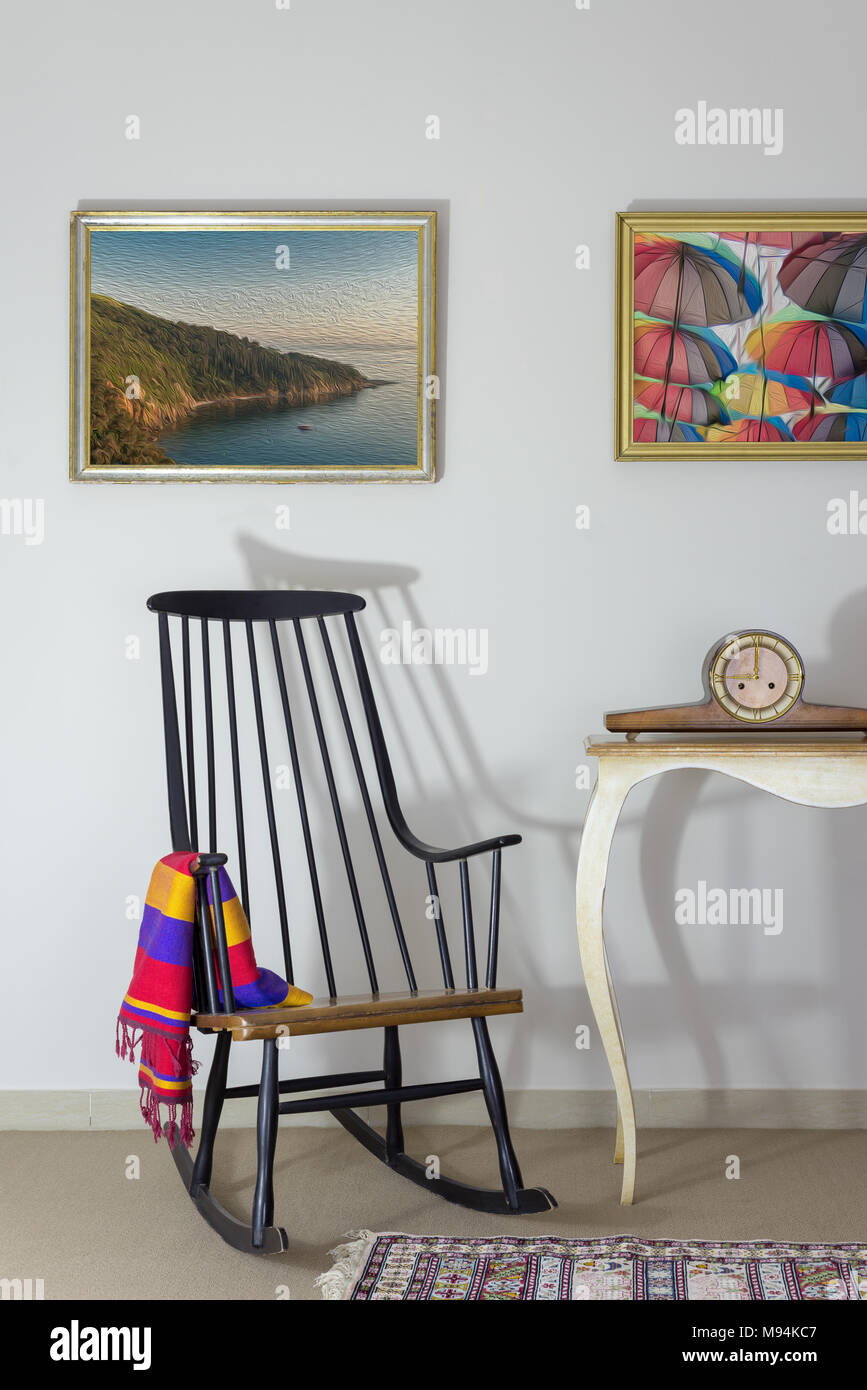 Interior shot of vintage rocking chair and antique desktop clock on old ...