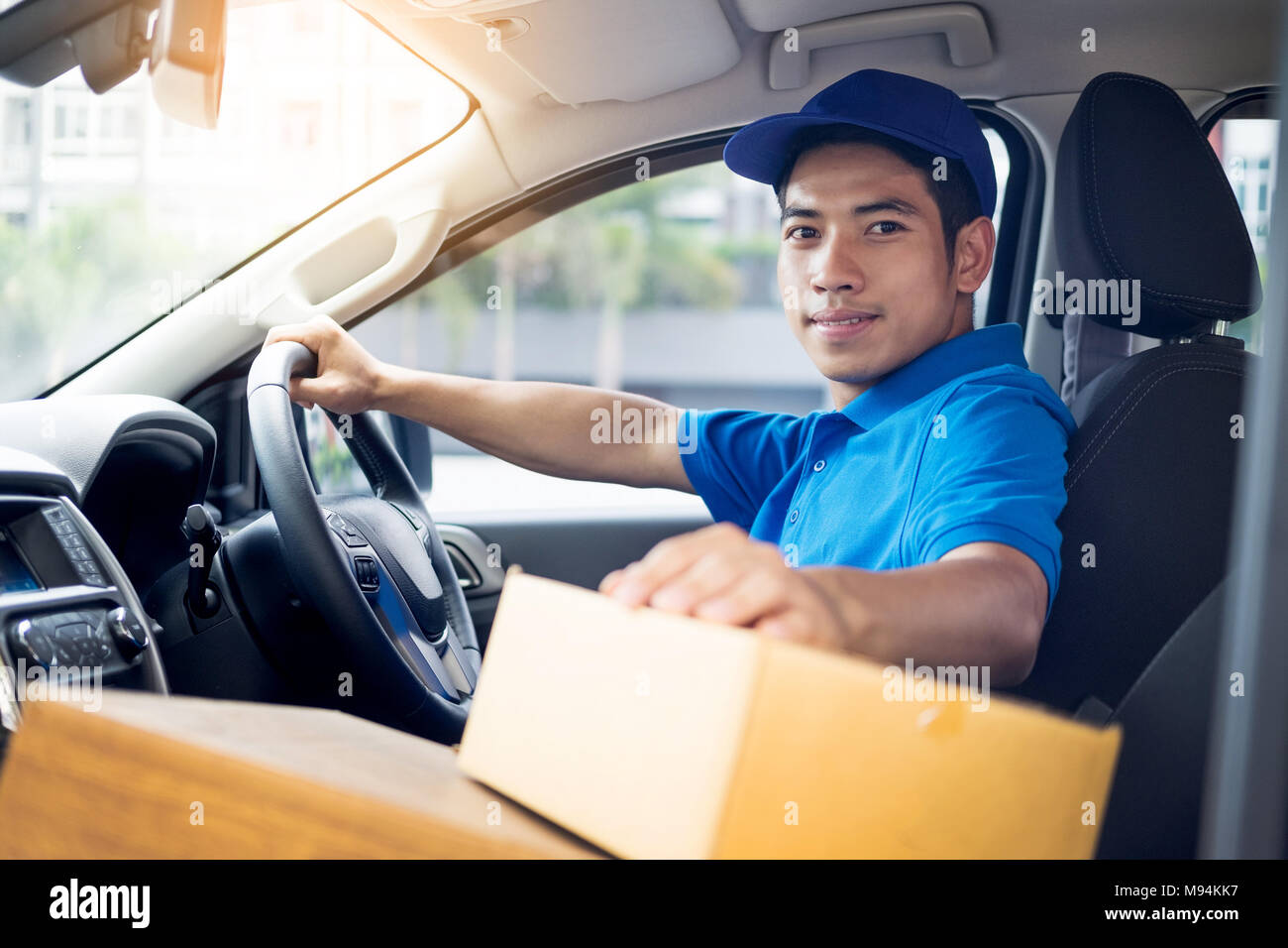 Delivery messenger man with cardboard box outside the warehouse Stock ...
