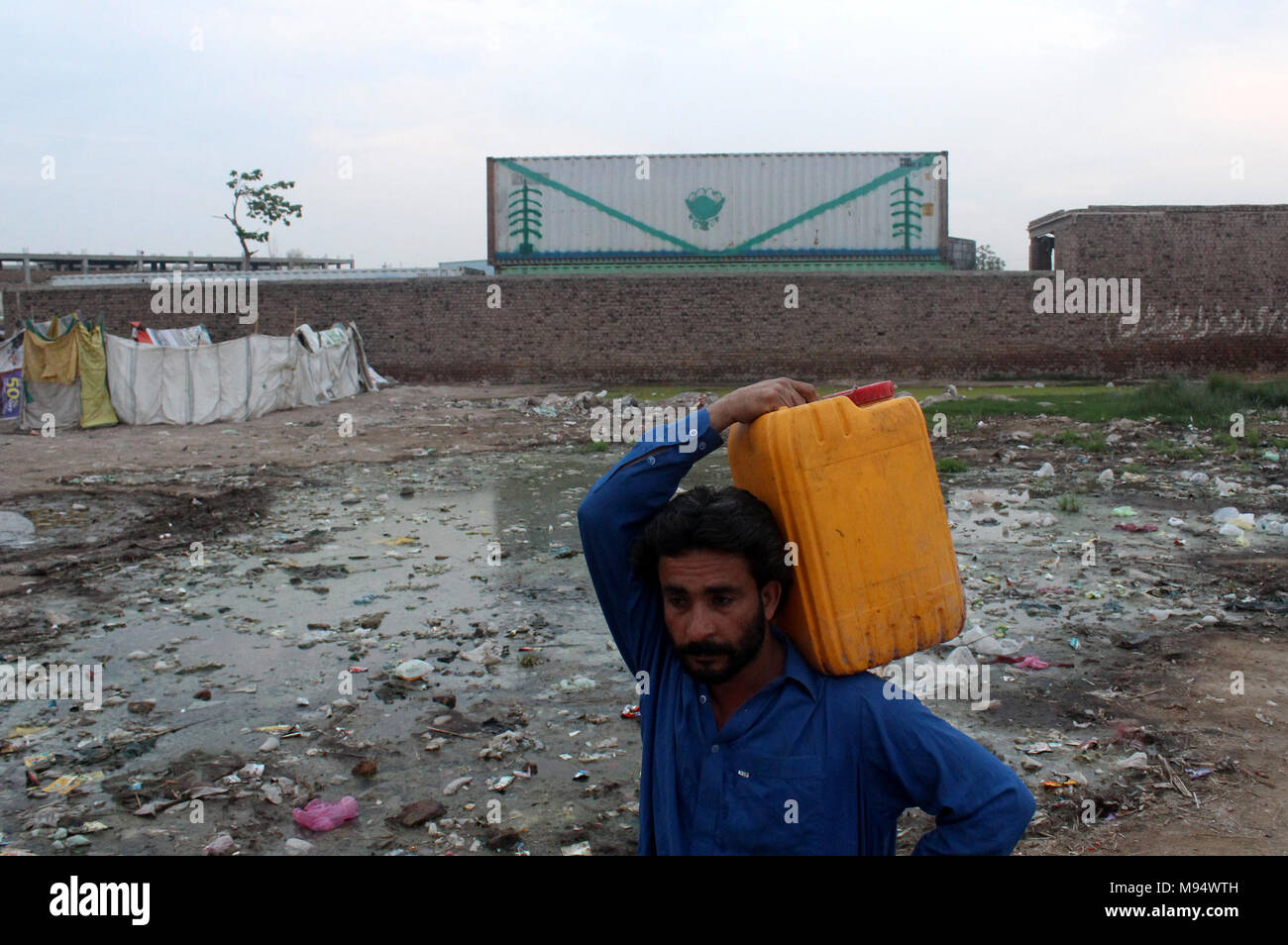 Peshawar. 22nd Mar, 2018. A Pakistani man carries a water tank at a ...