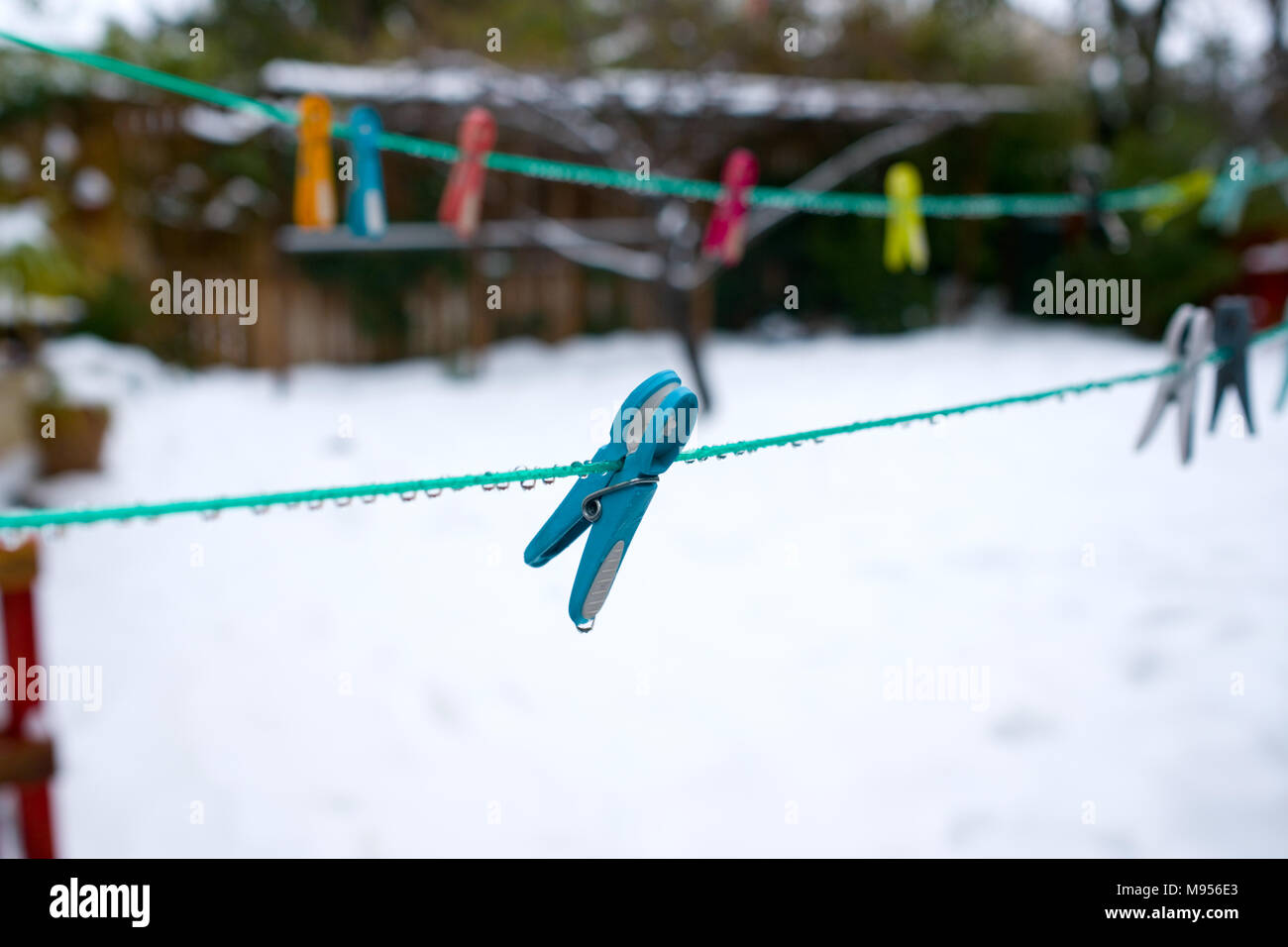 a macro shot of a clothes peg on a line in a snow filled garden Stock ...