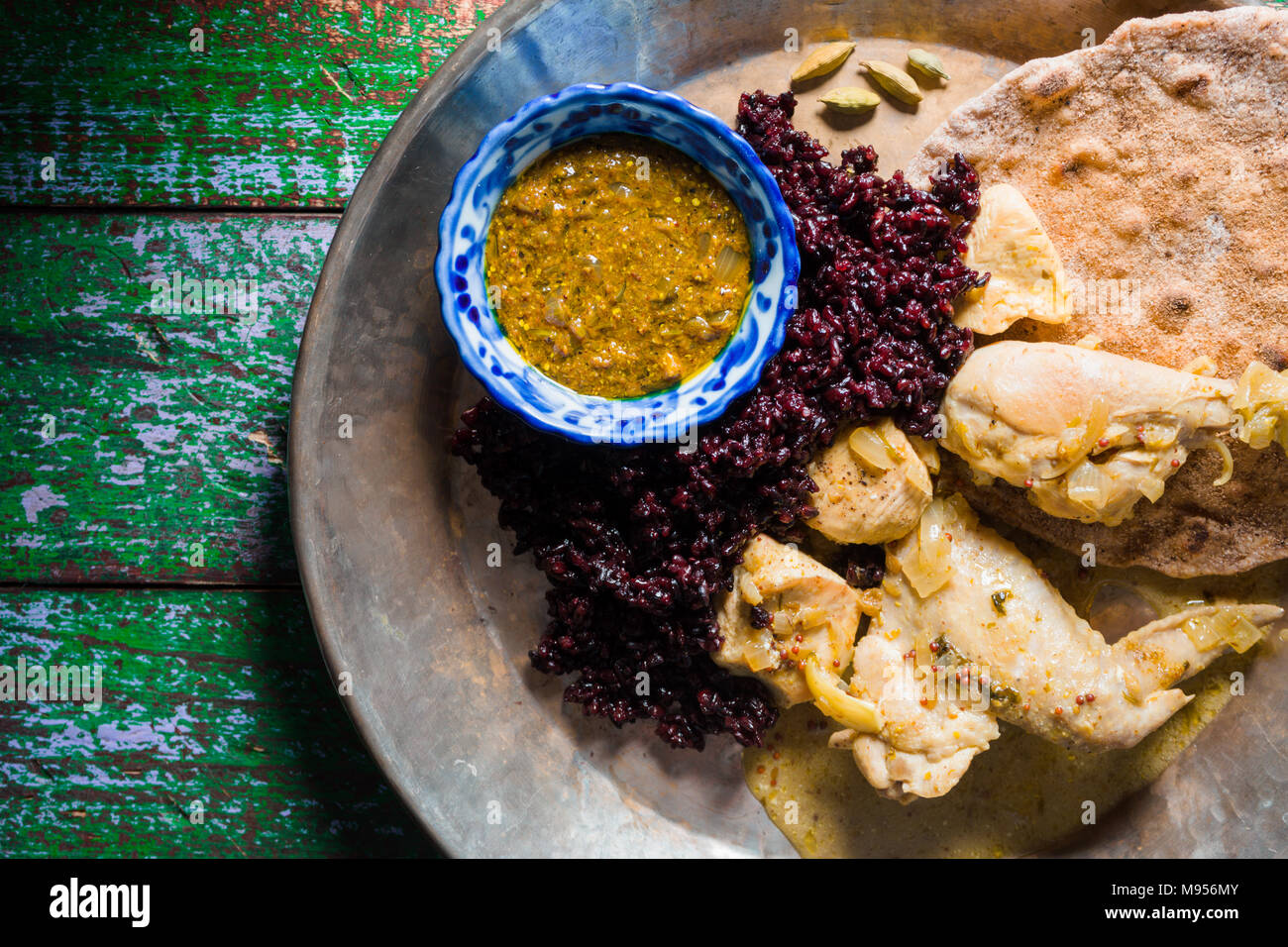 Chicken curry and bread chapati on a wooden stand. Indian dish ...