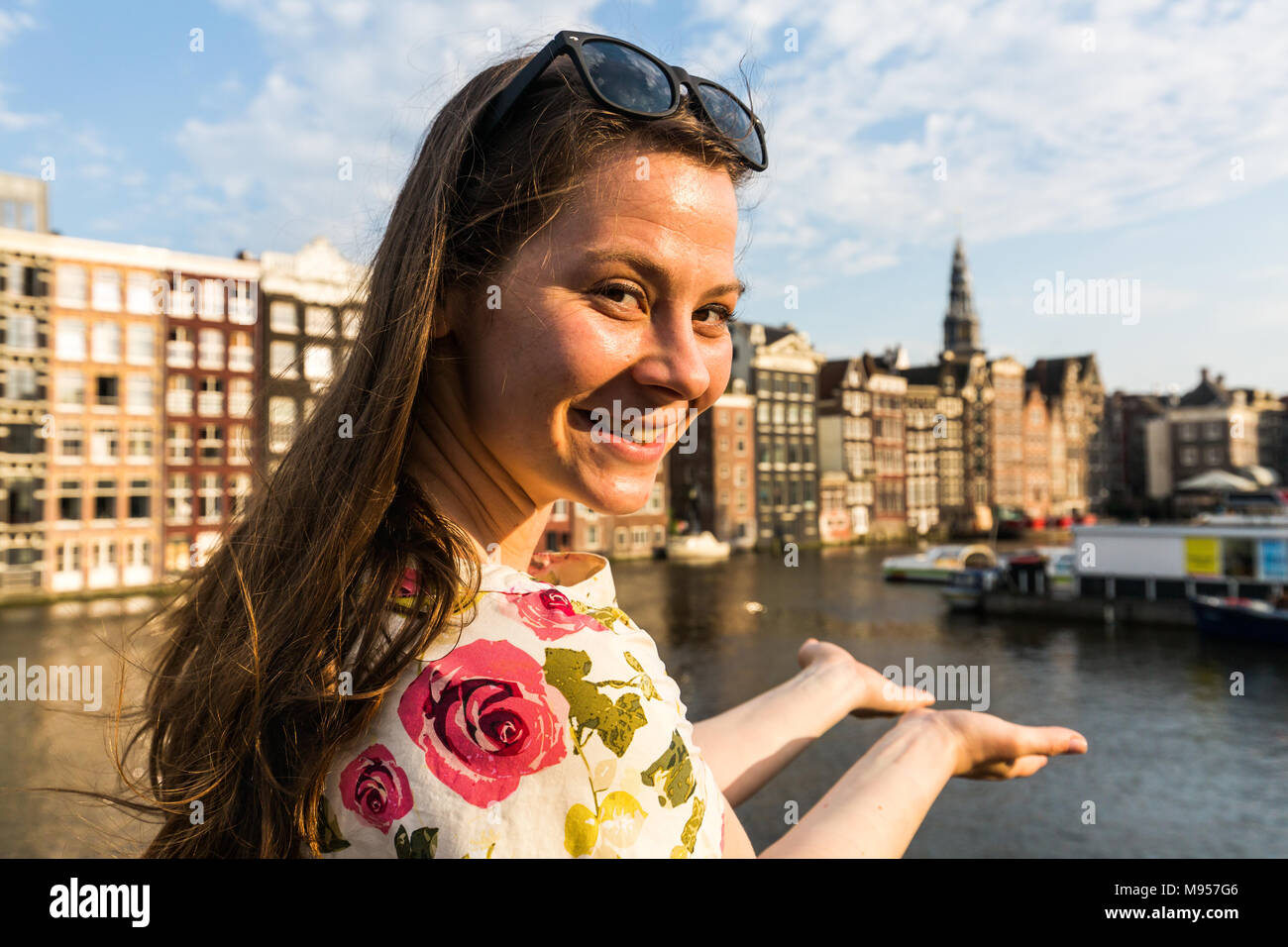 View of a tourist girl on sunset at the Damrak square in Amsterdam ...