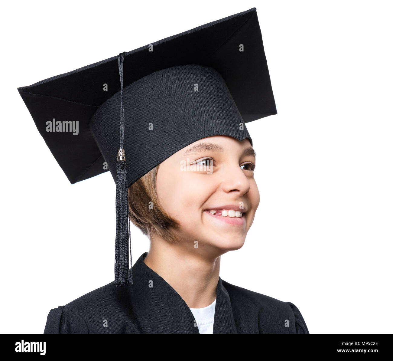 Portrait of graduate little girl student in black graduation gown with ...