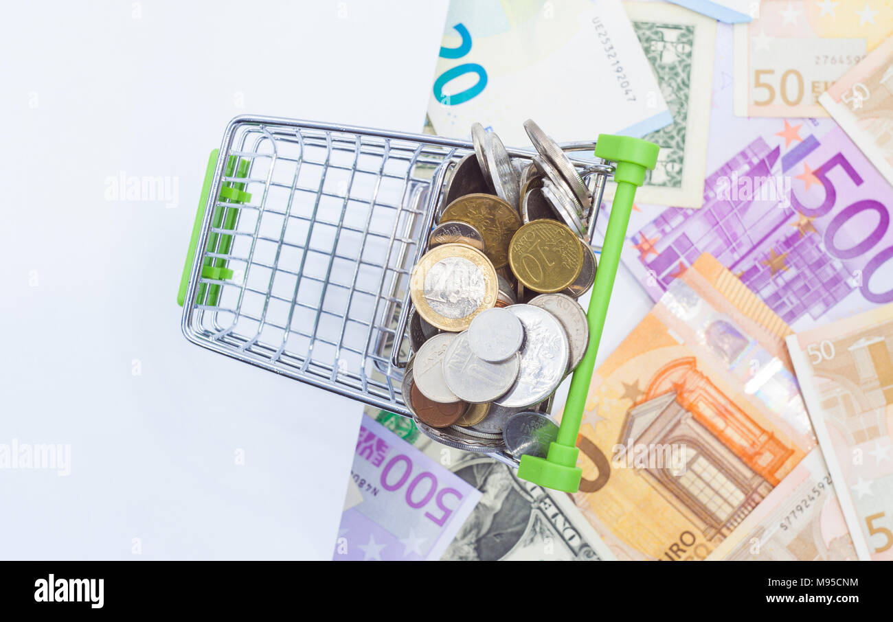 shopping cart with coins and banknotes in background. white board for ...