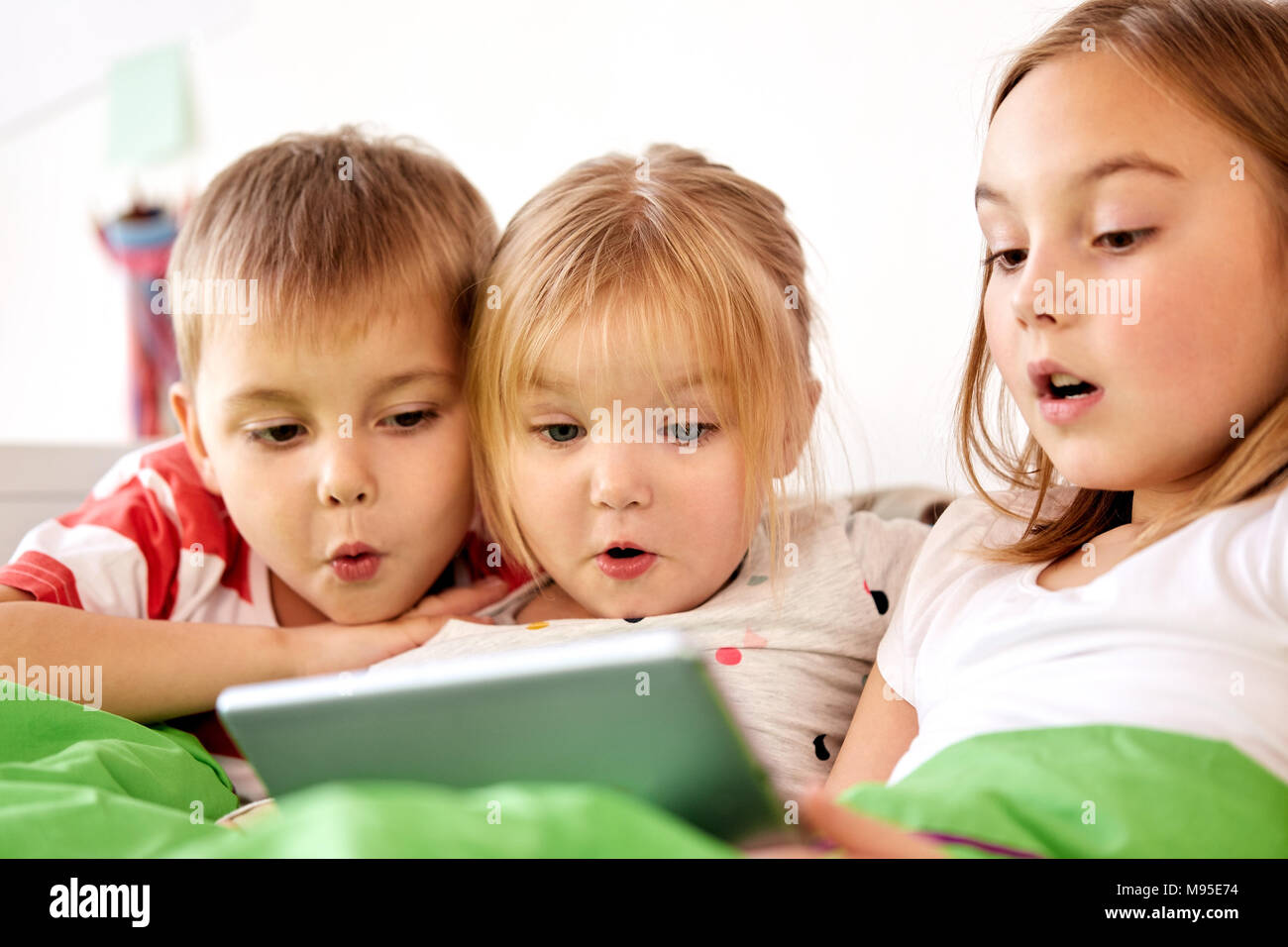 little kids with tablet pc in bed at home Stock Photo - Alamy