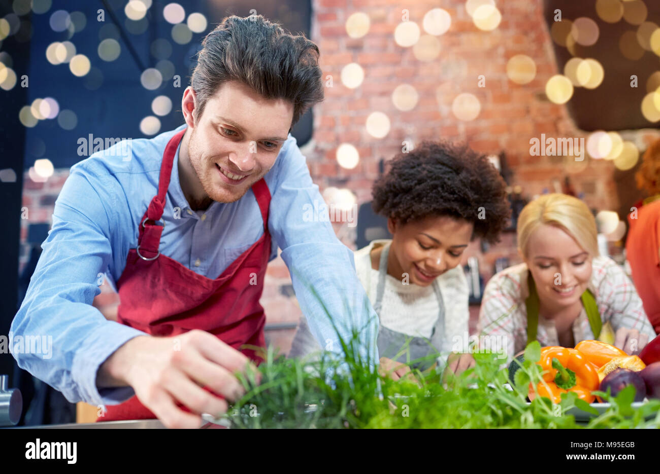 happy friends cooking and decorating dishes Stock Photo - Alamy