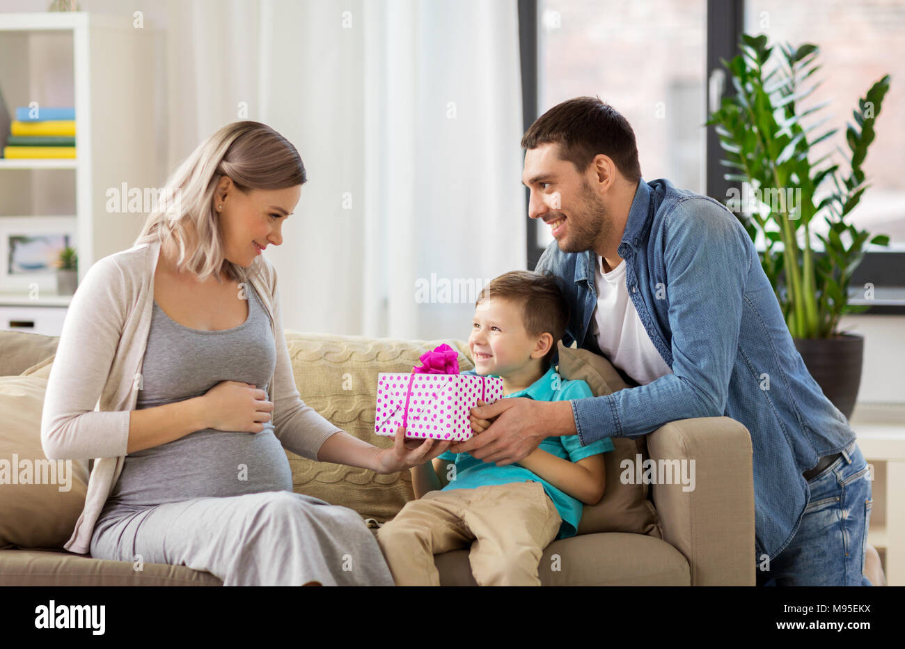 family giving present to pregnant mother at home Stock Photo - Alamy