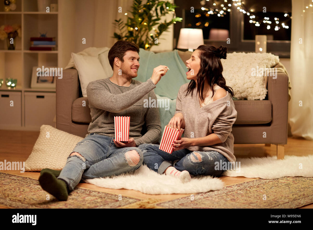 happy couple eating popcorn at home Stock Photo - Alamy