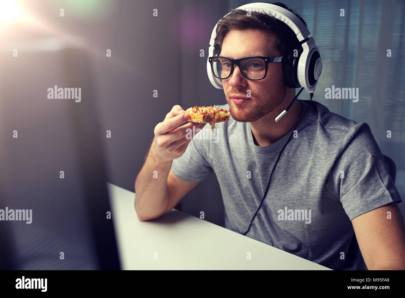 man in headset playing computer video game at home Stock Photo - Alamy