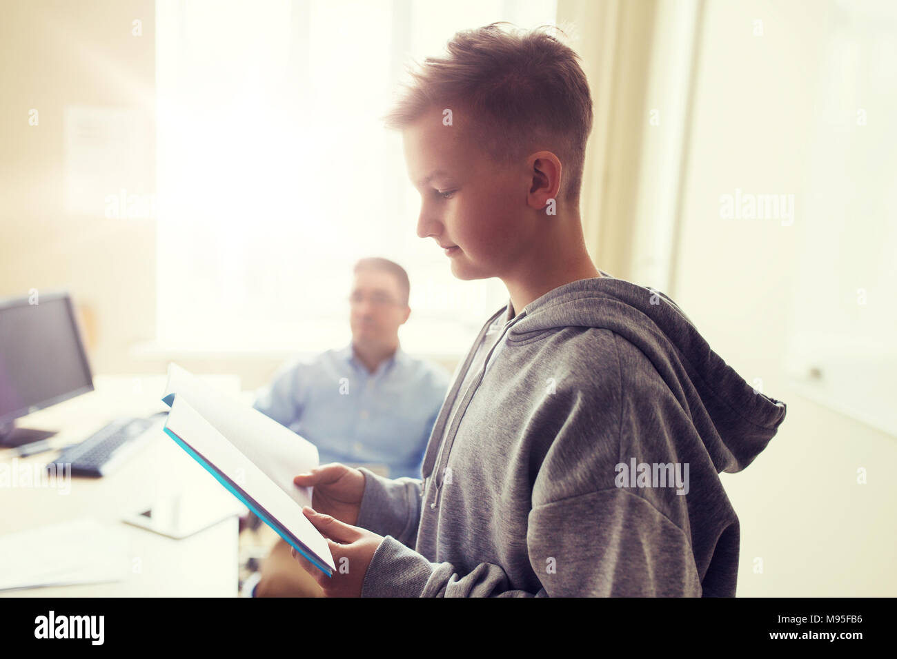 student boy with notebook and teacher at school Stock Photo - Alamy