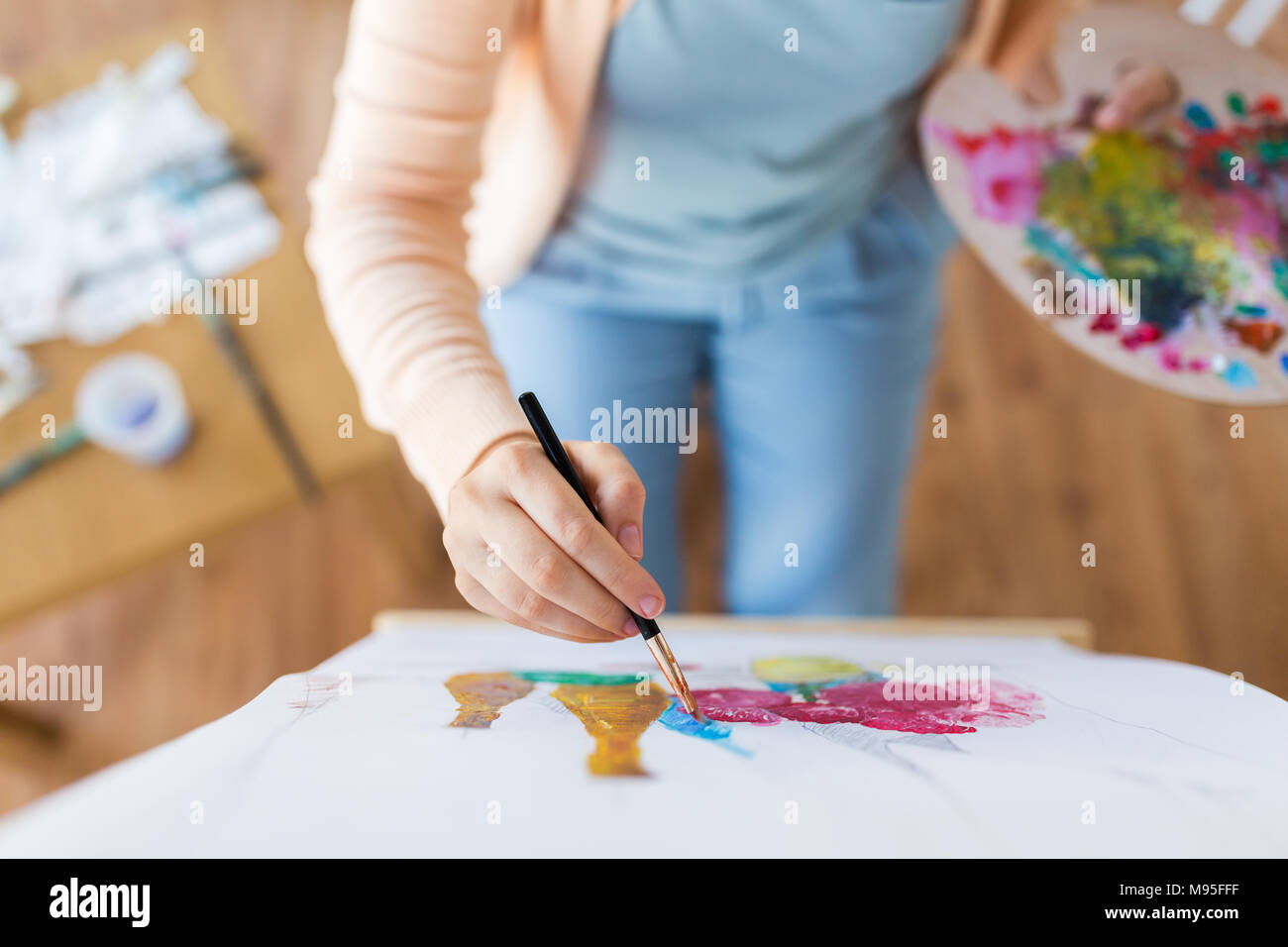artist with palette and brush painting at studio Stock Photo - Alamy