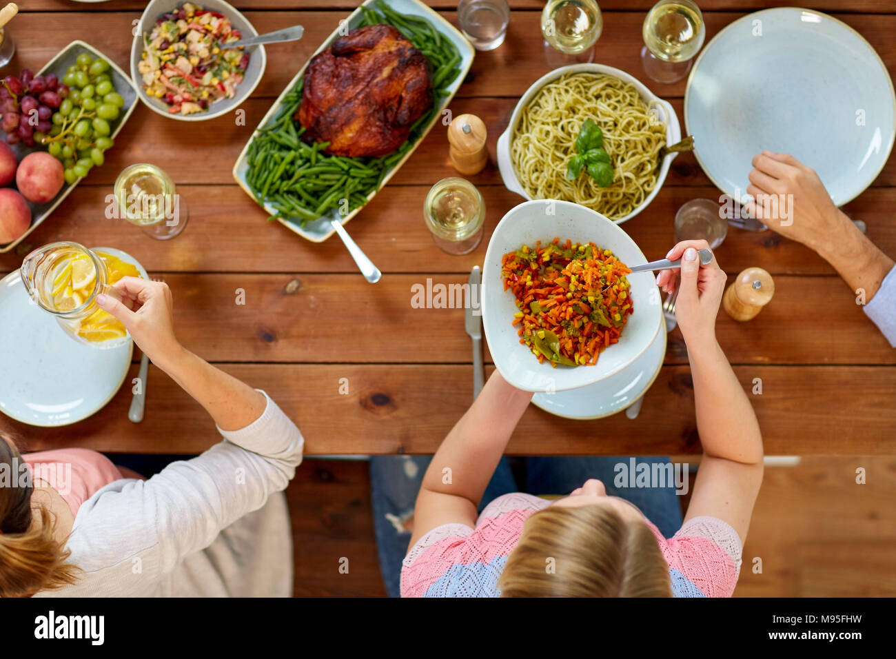 group of people eating at table with food Stock Photo - Alamy