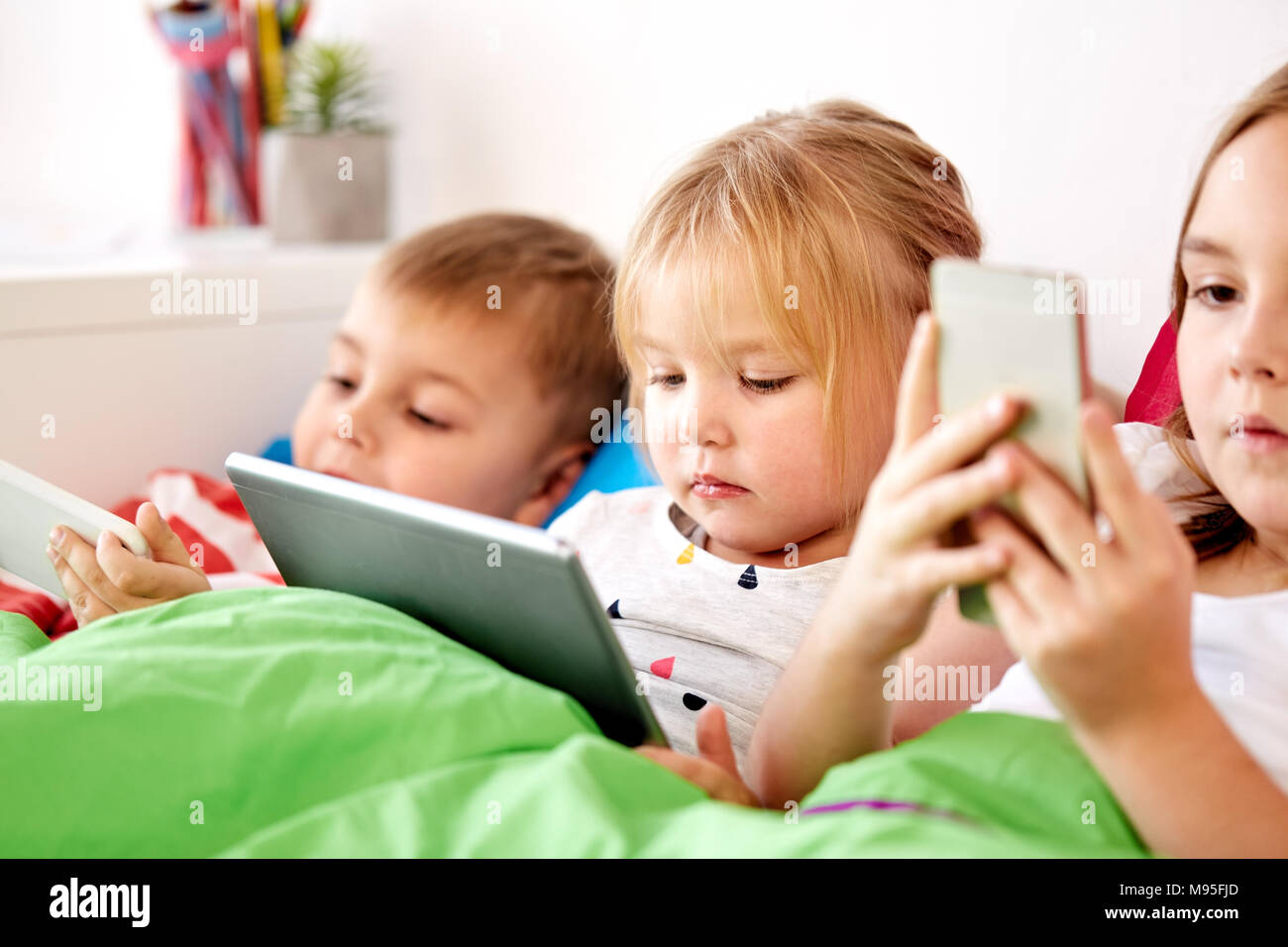 little kids with tablet pc in bed at home Stock Photo - Alamy