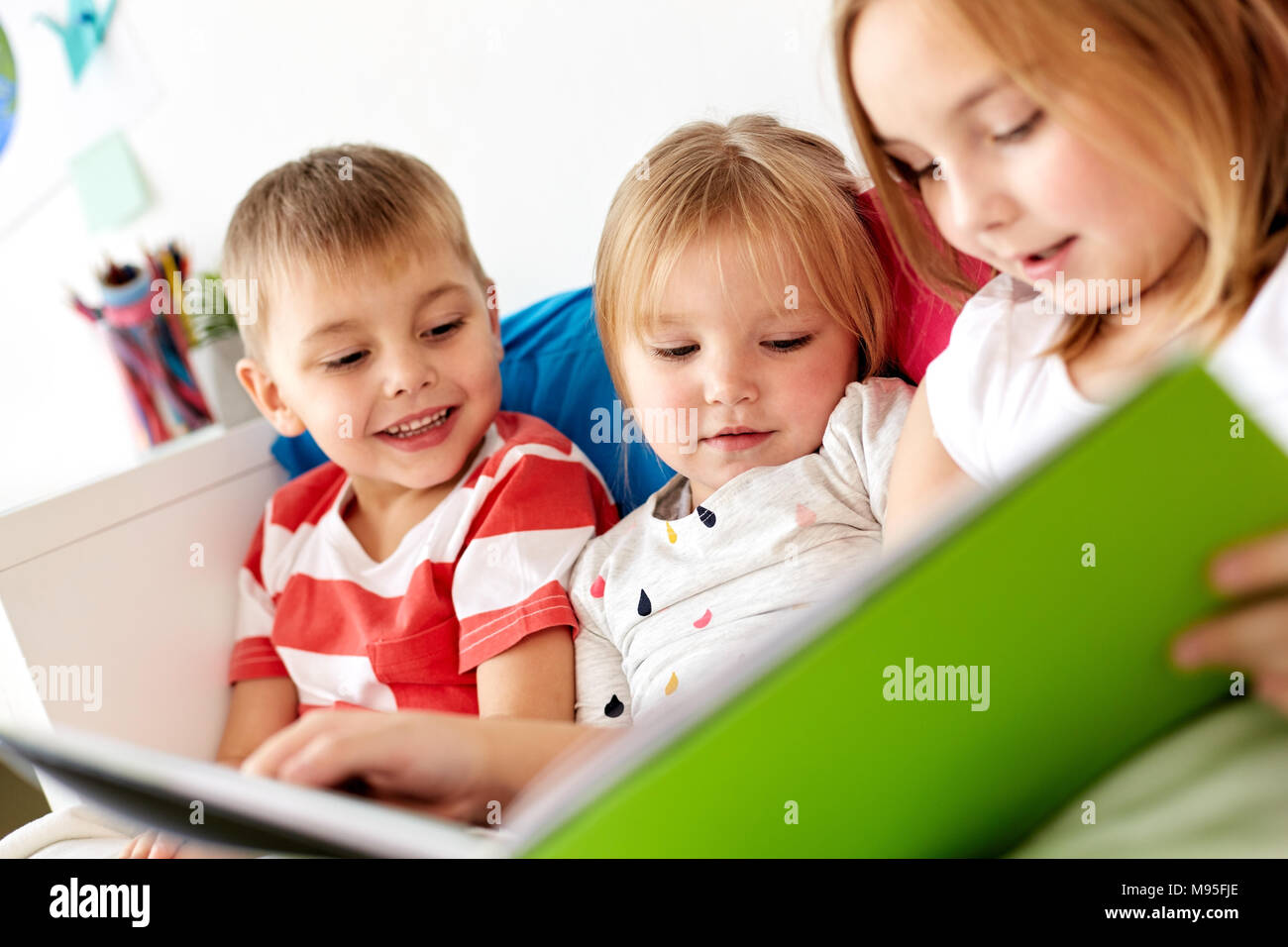 little kids reading book in bed at home Stock Photo - Alamy