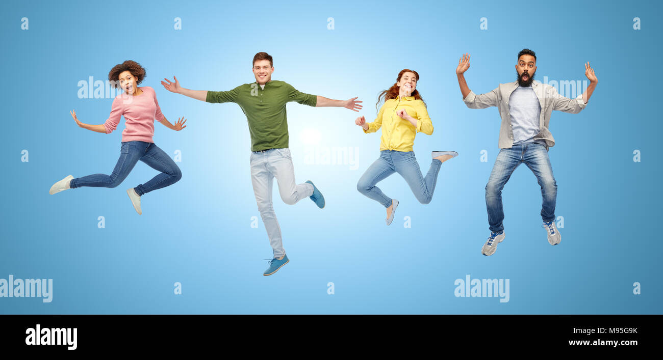 happy people or friends jumping in air over blue Stock Photo - Alamy
