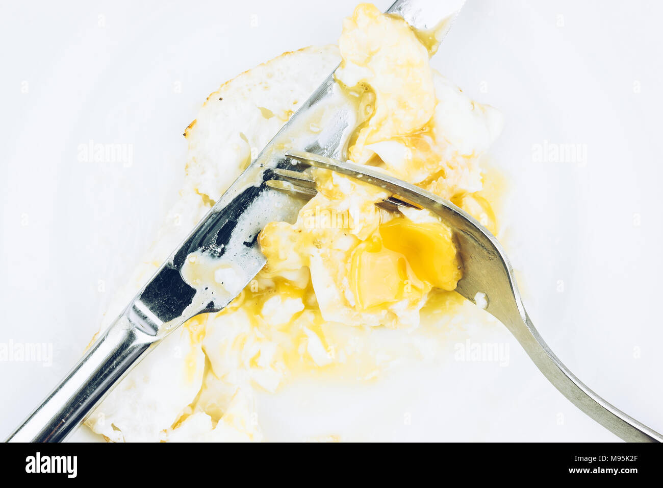 The remnants of food in plate. Fork and knife in a white plate with ...