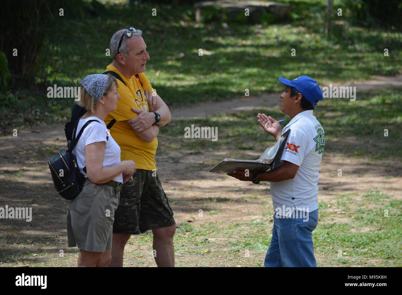 A tour guide with two tourists at the Acropolis pyramid at Ek Balam ...