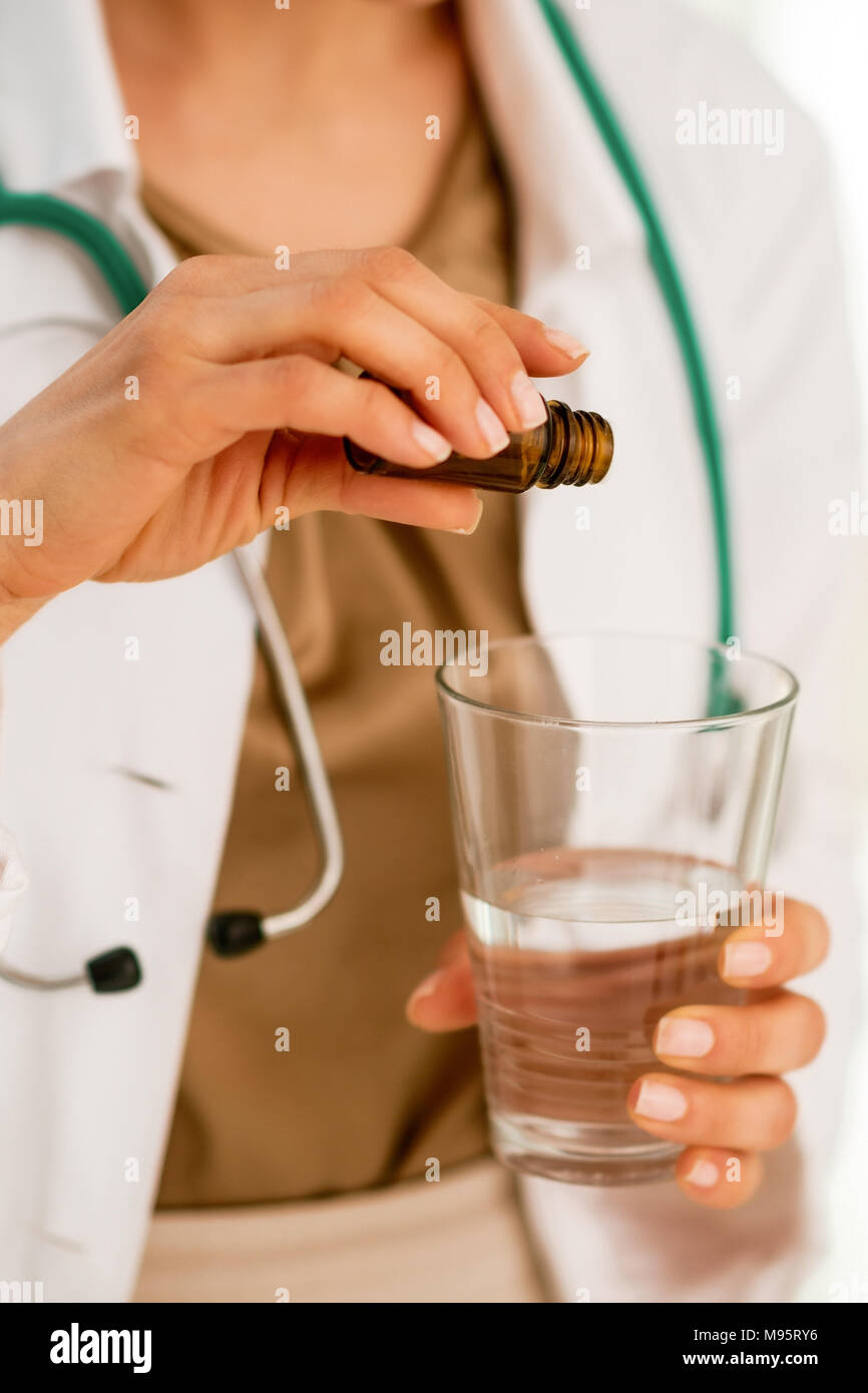 Closeup on medical doctor woman calmative into glass Stock Photo - Alamy