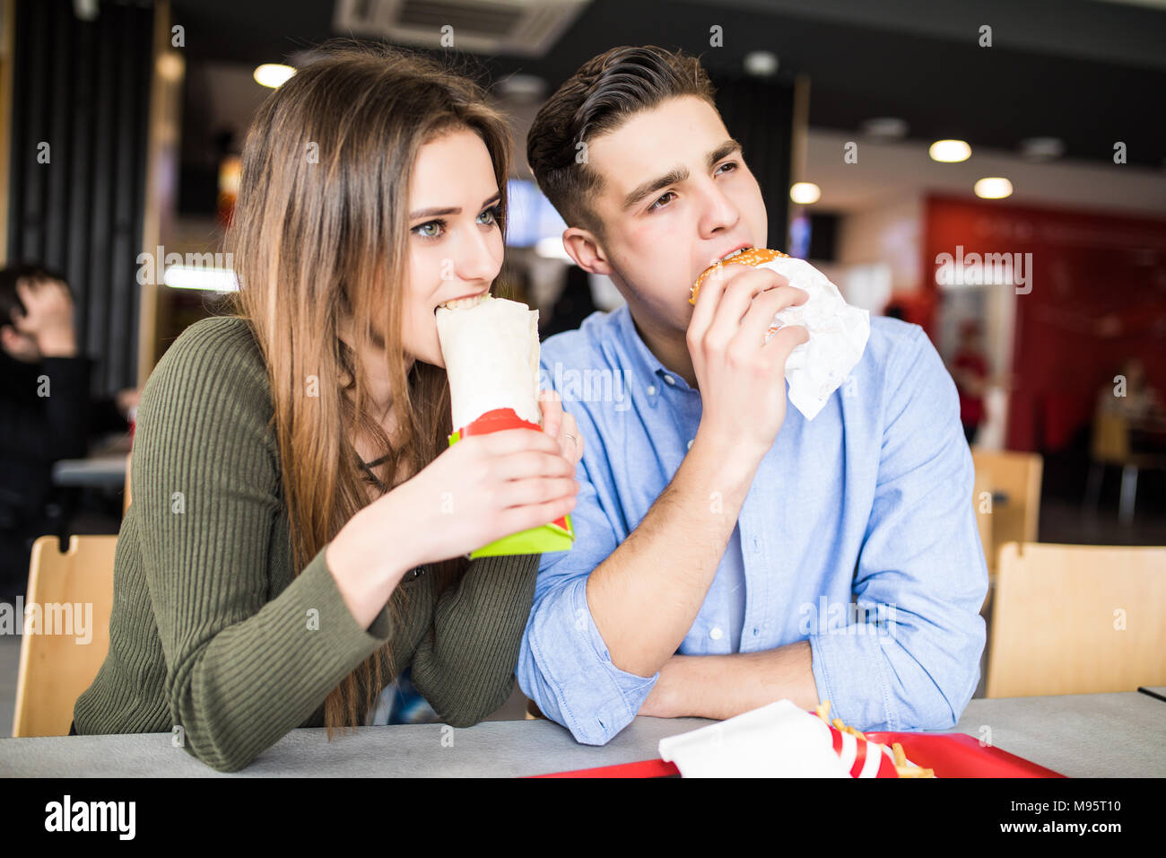 Couple eating burgers in burger bar hi-res stock photography and images ...